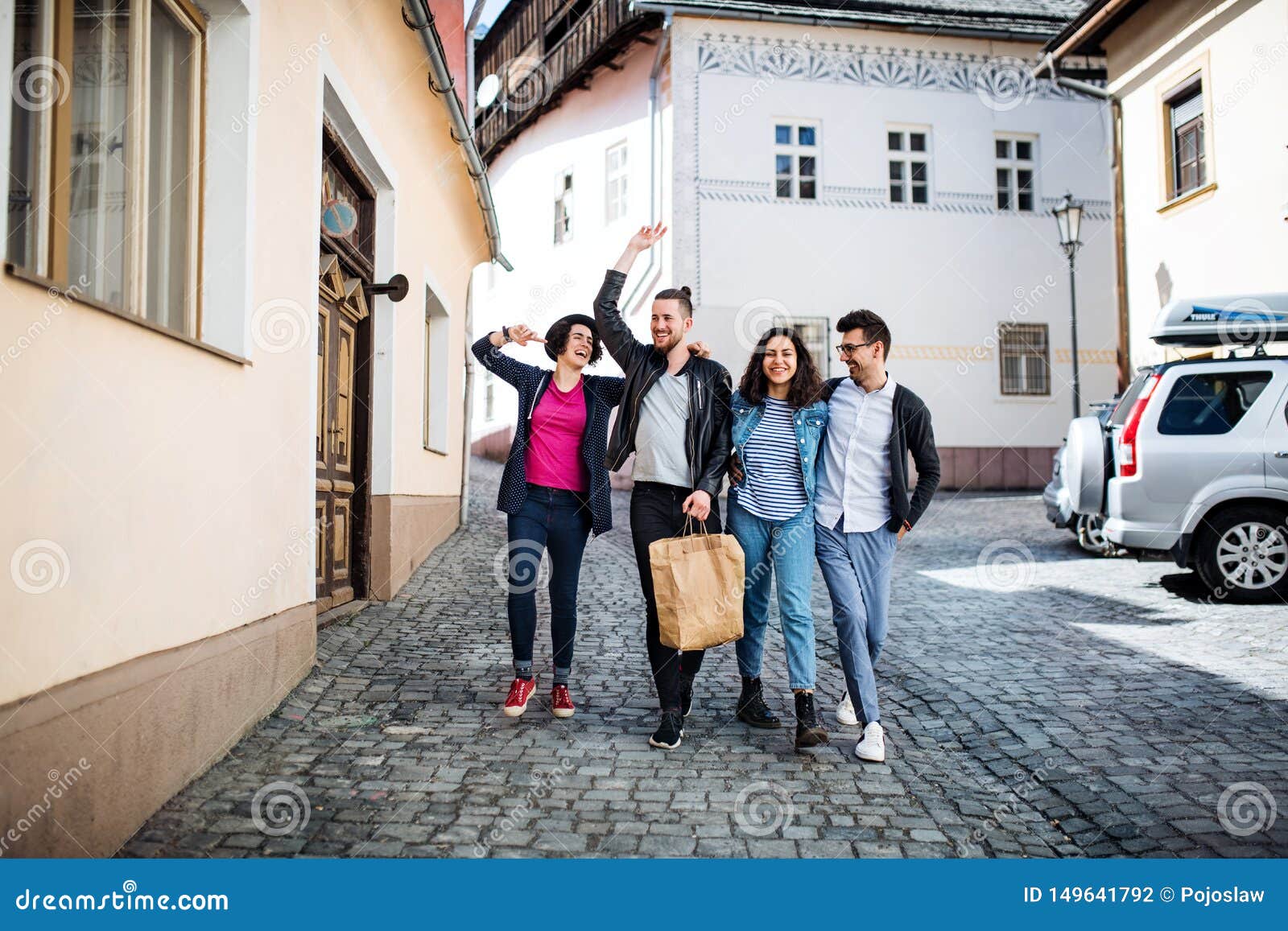 A Group of Young Friends Walking Outdoor in Town, Talking. Stock Photo ...