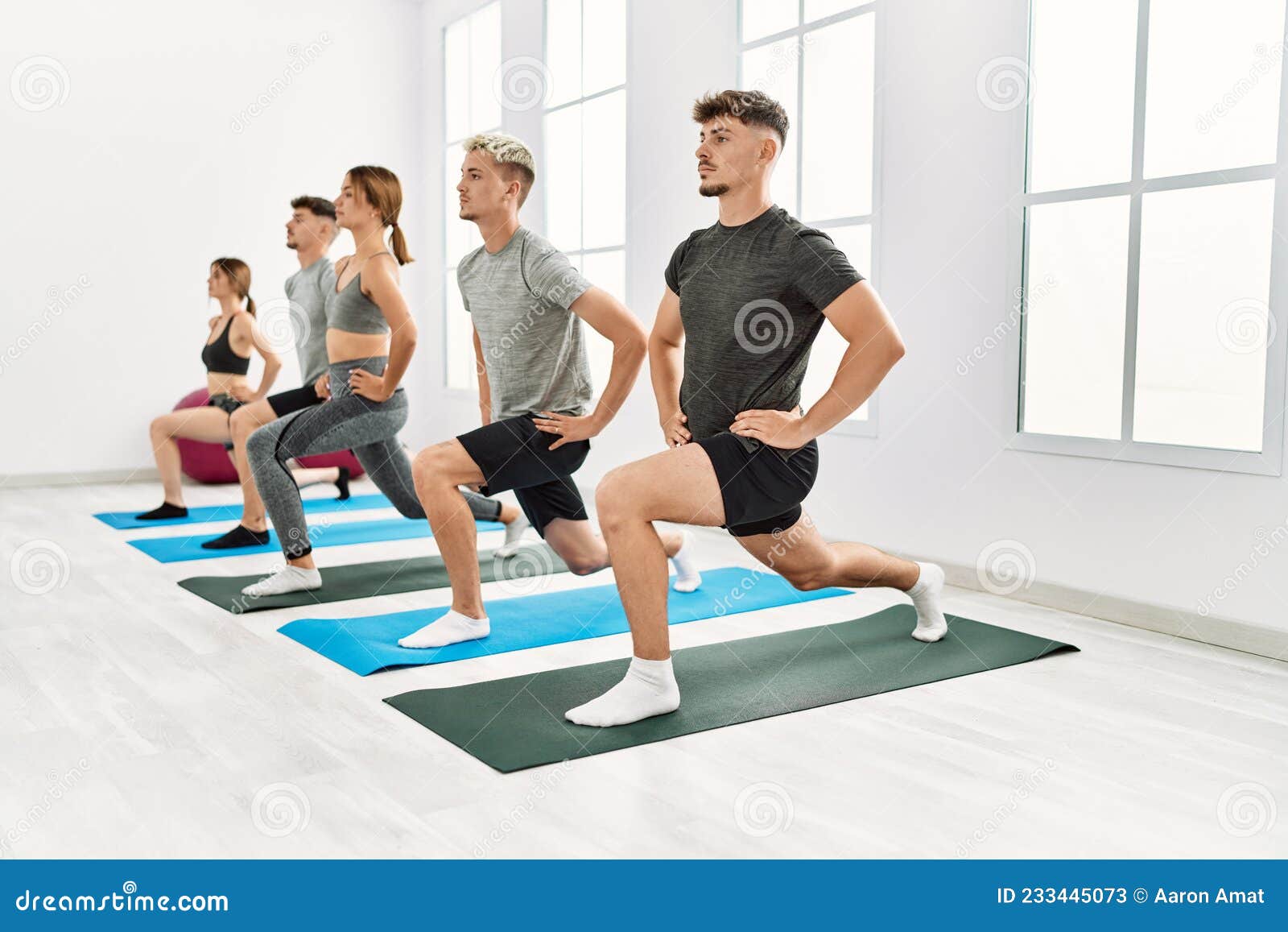 Group of Young Hispanic People Concentrate Training Legs Exercise at ...