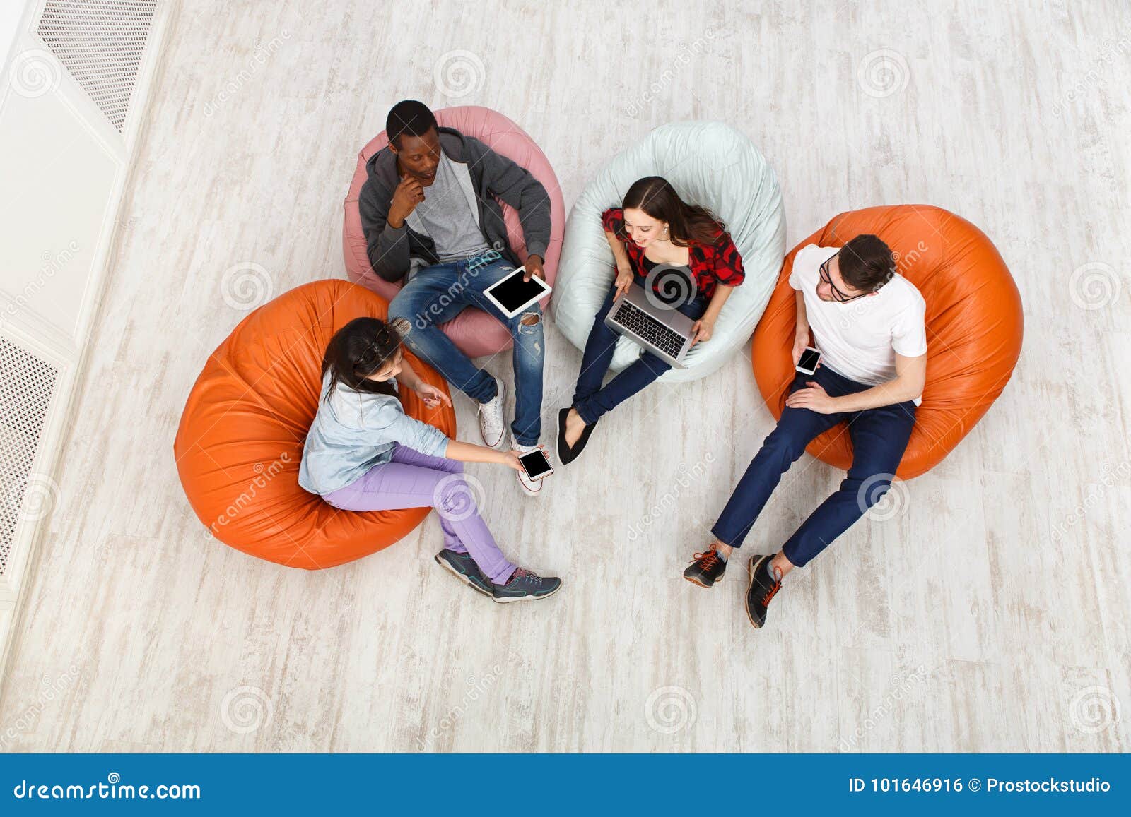 Friends Using Gadgets, Sitting Indoors in Line Stock Photo - Image of ...