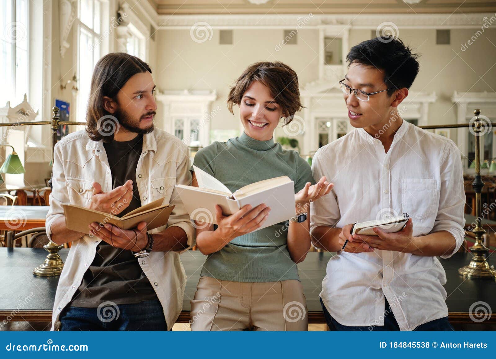 Group of Young Multinational Students Happily Studying with Book and ...