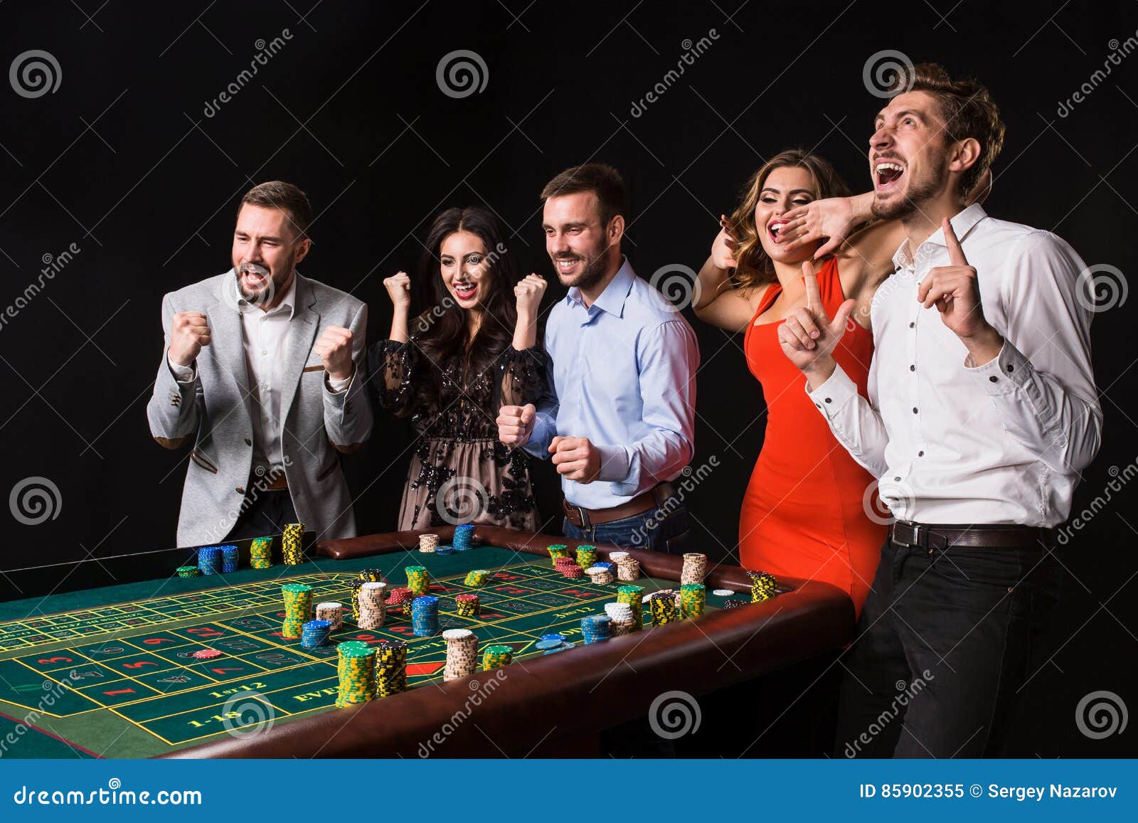 Group of Young People Behind Roulette Table on Black Background Stock ...