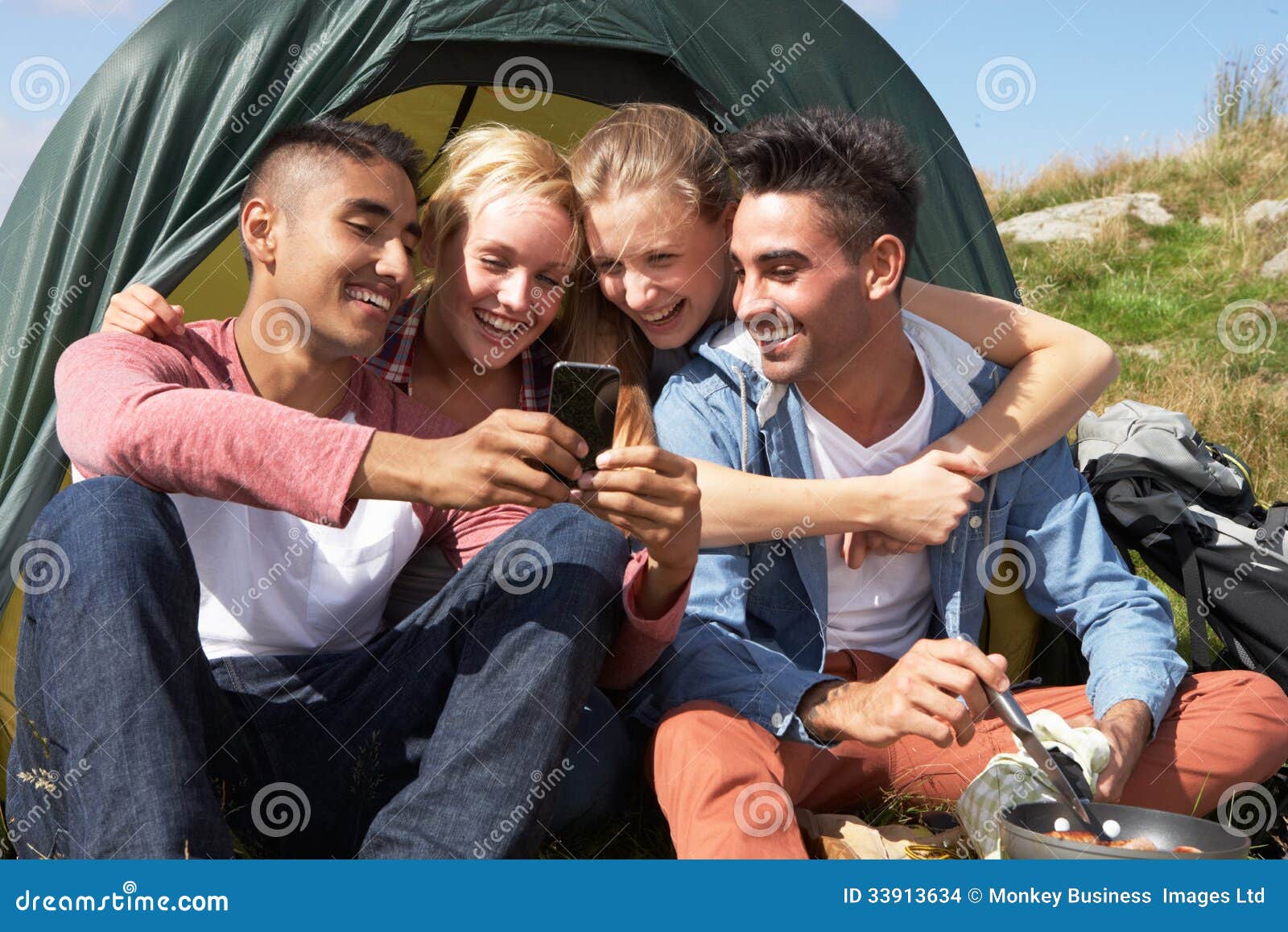 Group of Young People Checking Mobile Phone on Camping Trip Stock Photo ...
