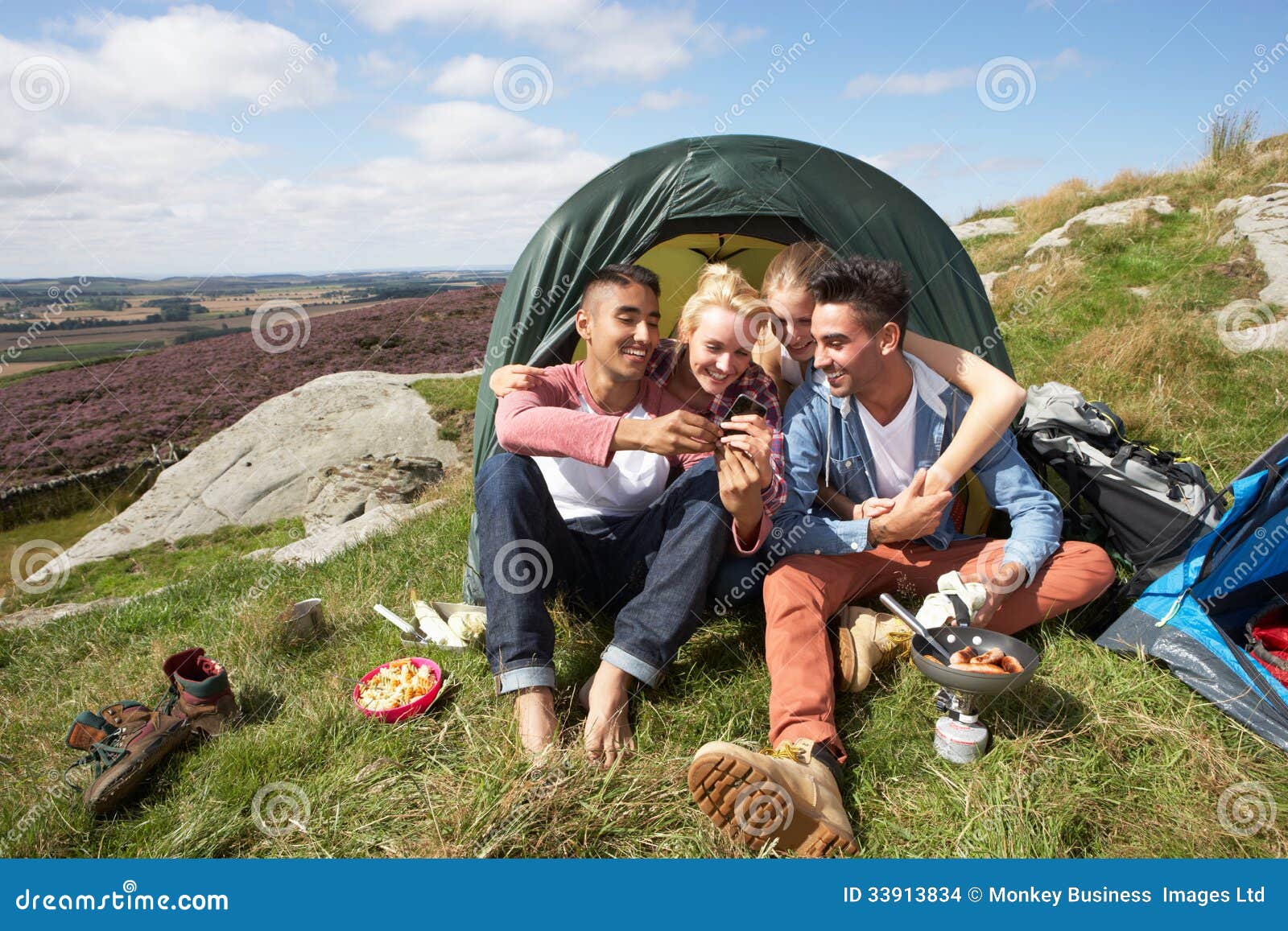 Group of Young People Checking Mobile Phone on Camping Trip Stock Photo ...