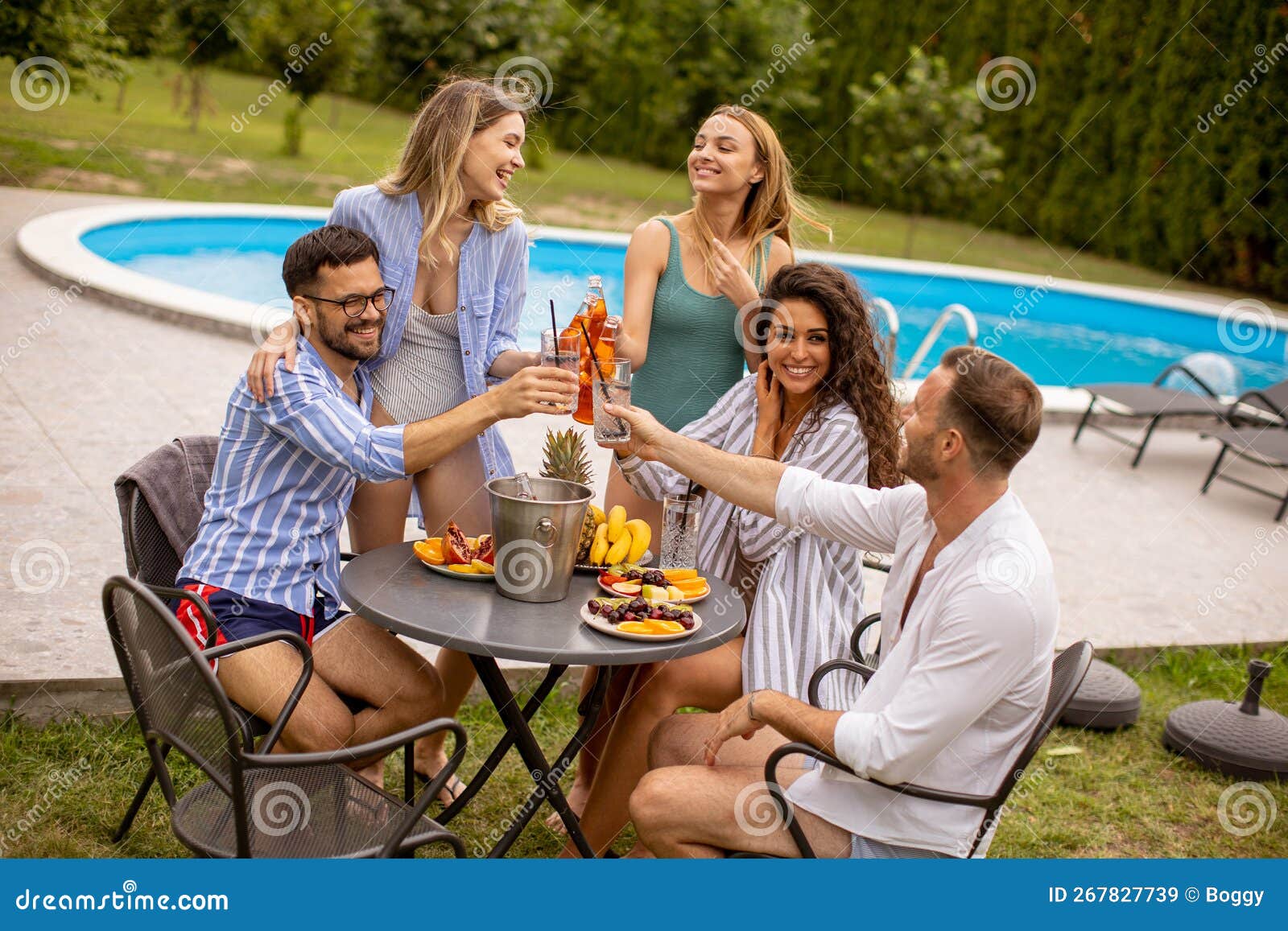 Group of Young People Cheering with Cider by the Pool in the Garden ...