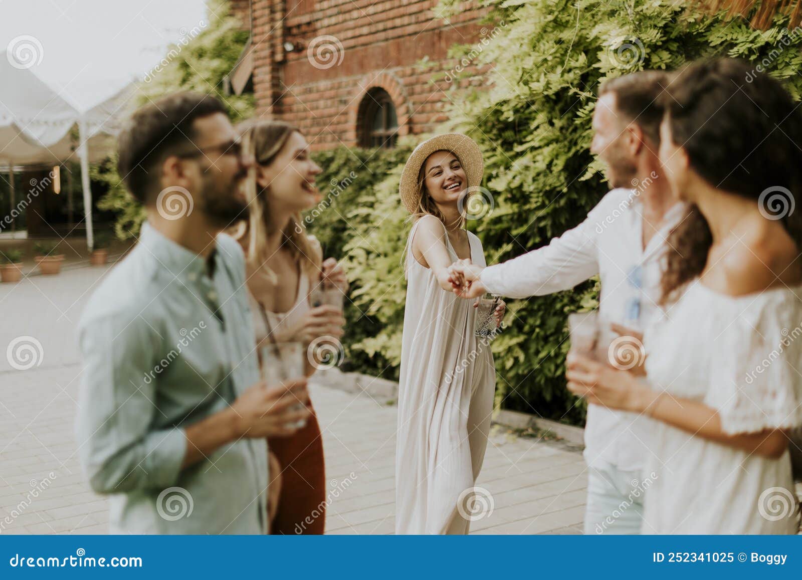 Group of Young People Cheering and Having Fun Outdoors with Drinks ...