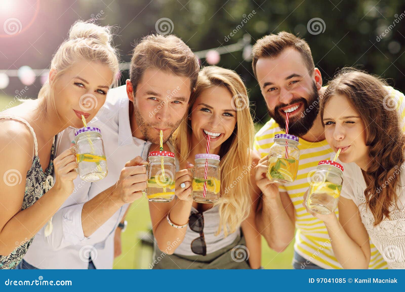 Group of Young People Cheering and Having Fun Outdoors with Drinks ...