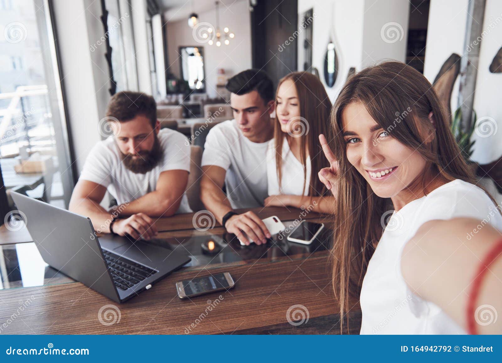 A Group of Young People with Gadgets and a Laptop Arrange a Brainstorm ...