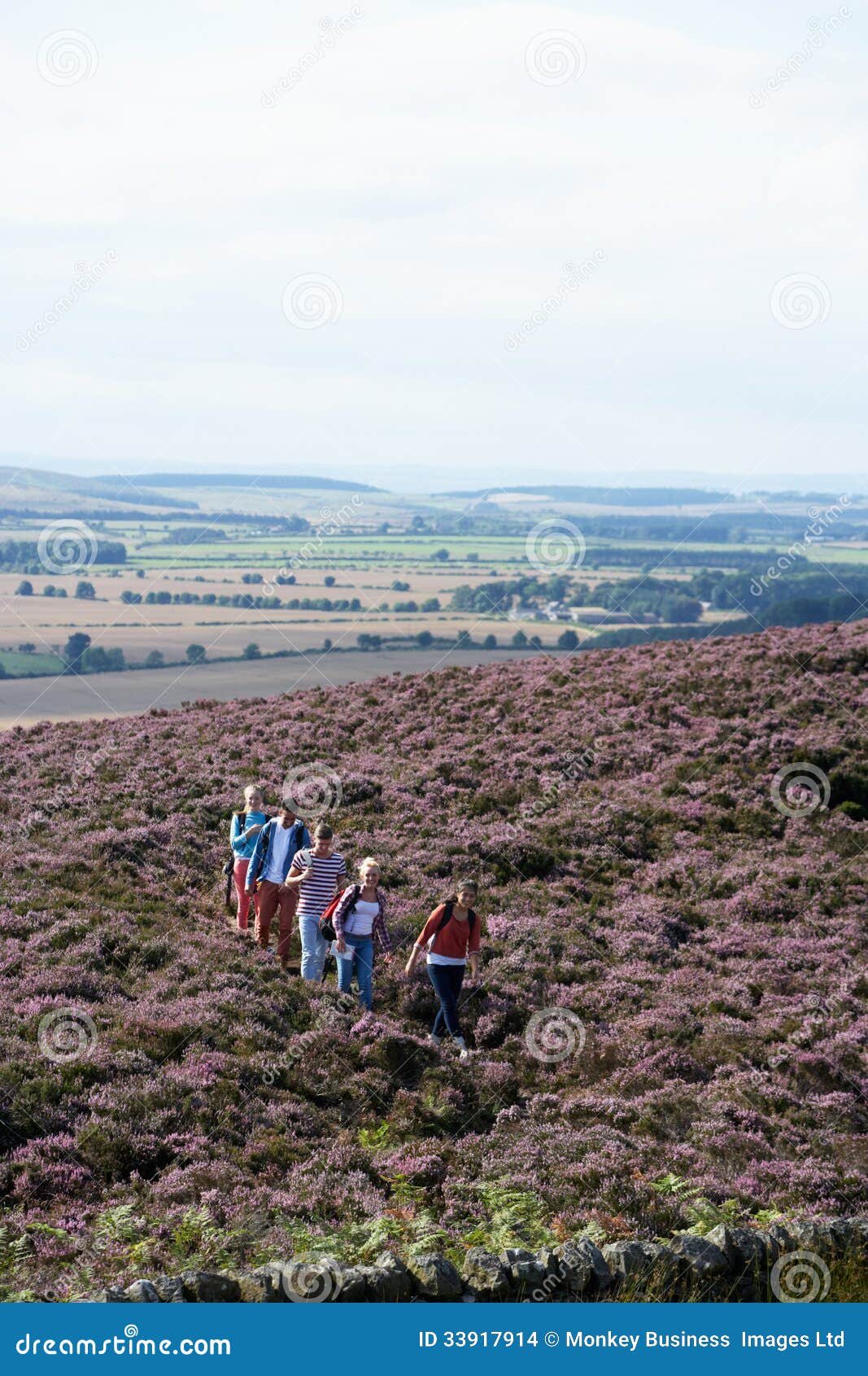 Group of Young People Hiking through Countryside Stock Photo - Image of ...