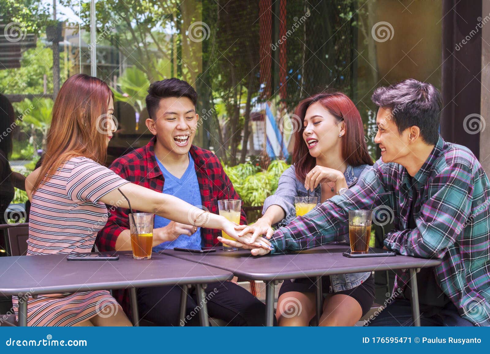 Group of Young People Joining Hands in Restaurant Stock Image - Image ...