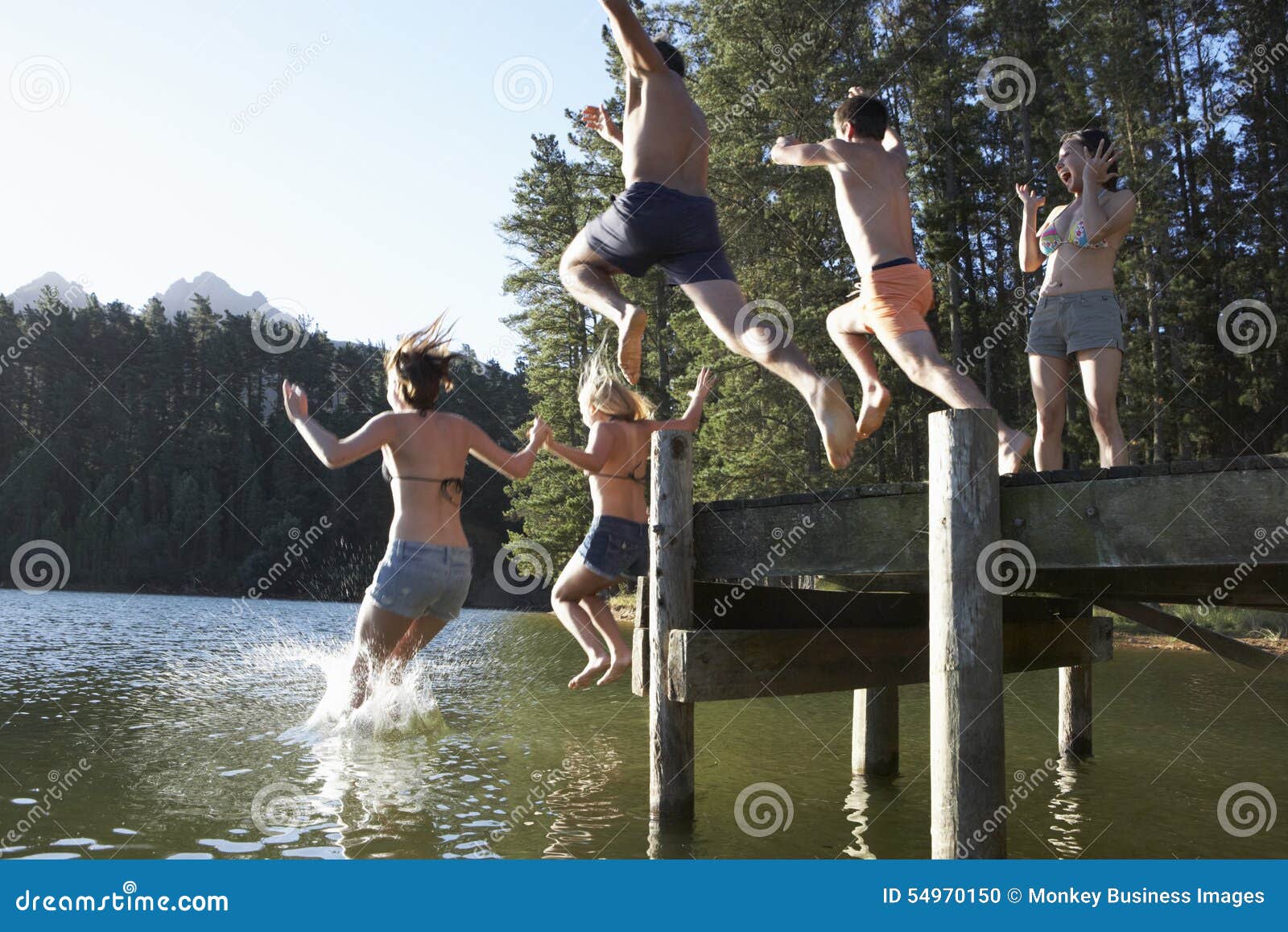 Group of Young People Jumping from Jetty into Lake Stock Photo - Image ...