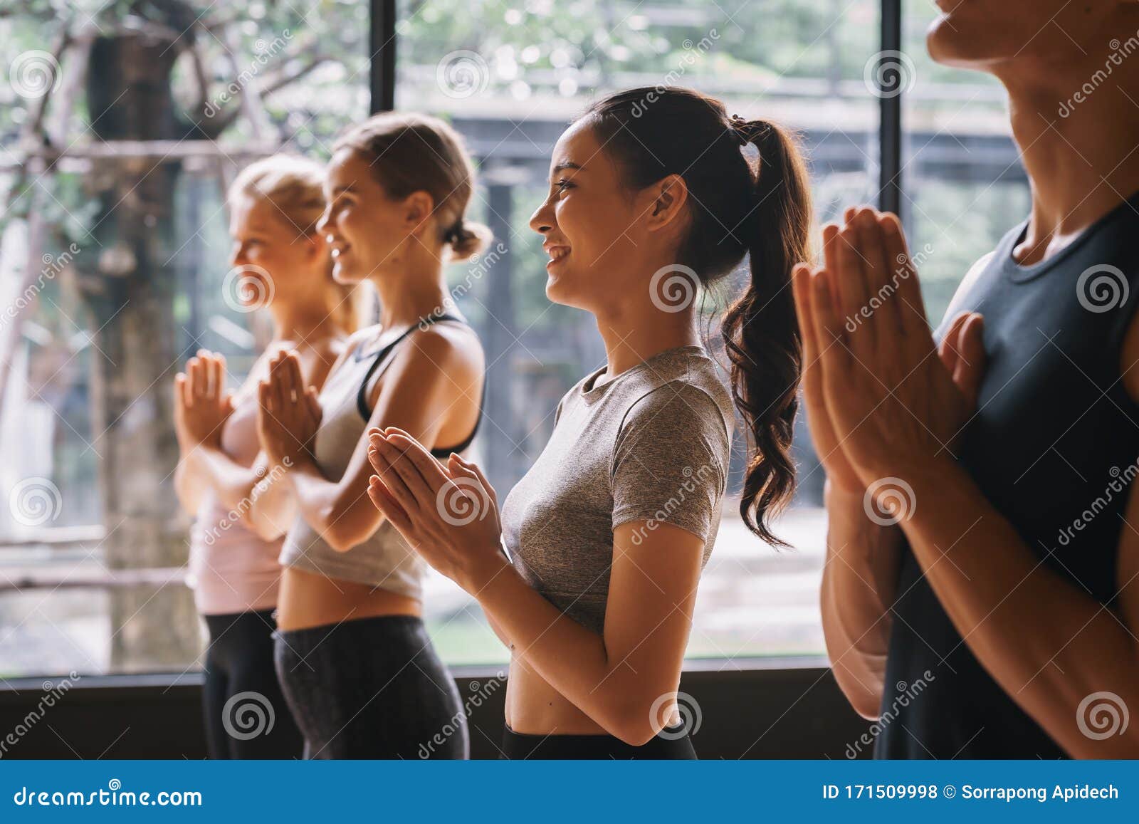 Group of Young People Practicing Yoga in the Prayer Position at Gym ... Group of Young People Practicing Yoga in the Prayer Position at Gym ...