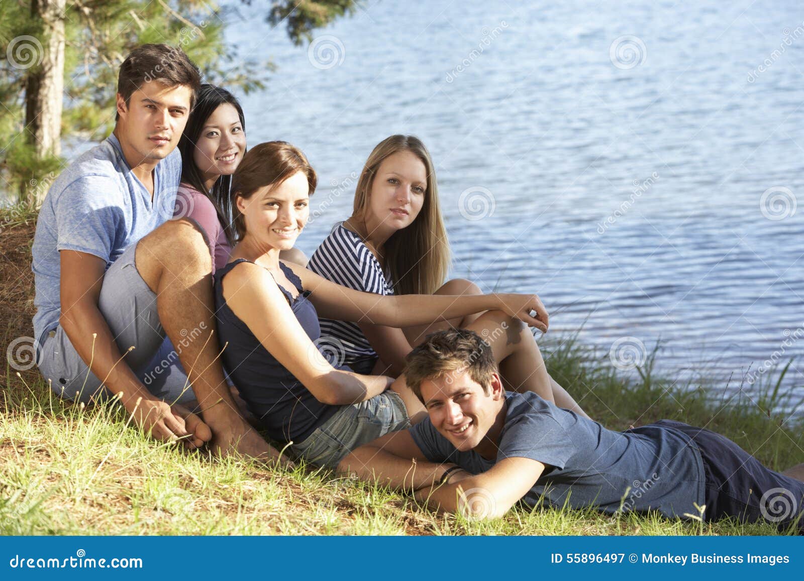 Group of Young People Relaxing at Shore of Lake Stock Image - Image of ...