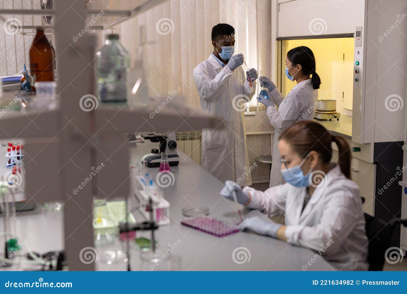Group of Young Scientists Working with Fluids in Flasks Stock Photo ...