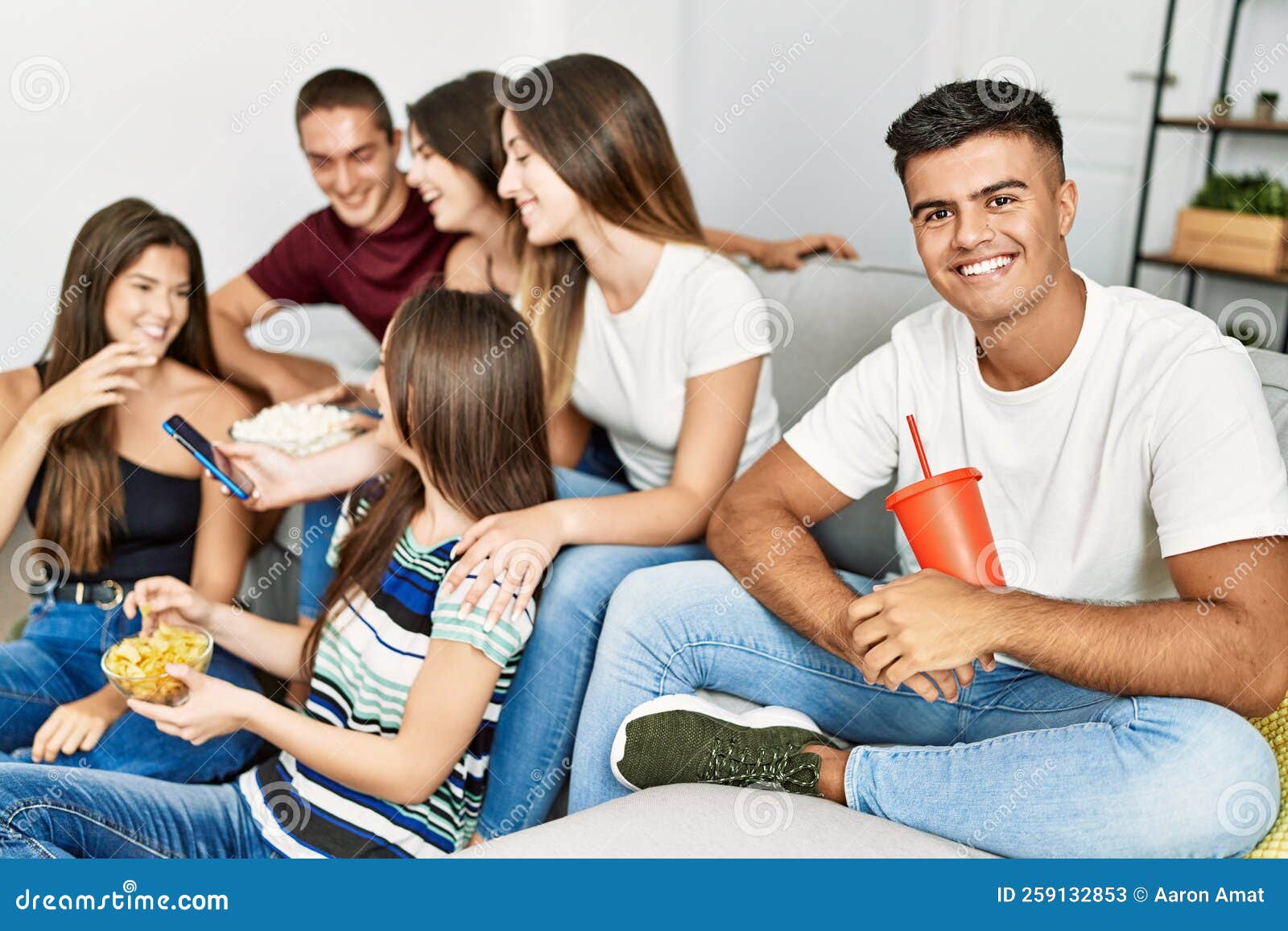 Group of Young Smiling Happy Sitting on the Sofa Eating at Home Stock ...