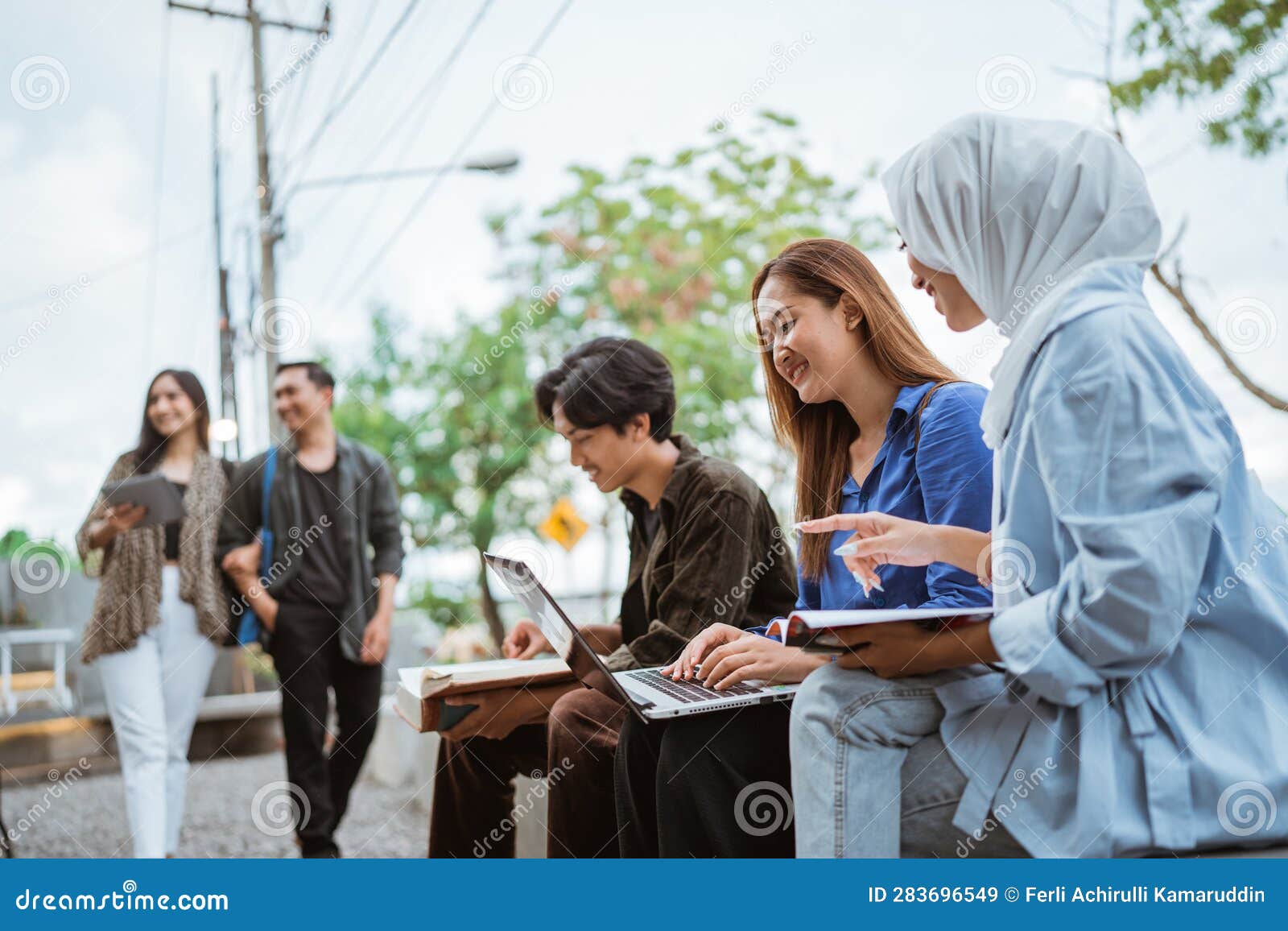 Group of Young Students Studying Using a Laptop in an Outdoor Cafe ...
