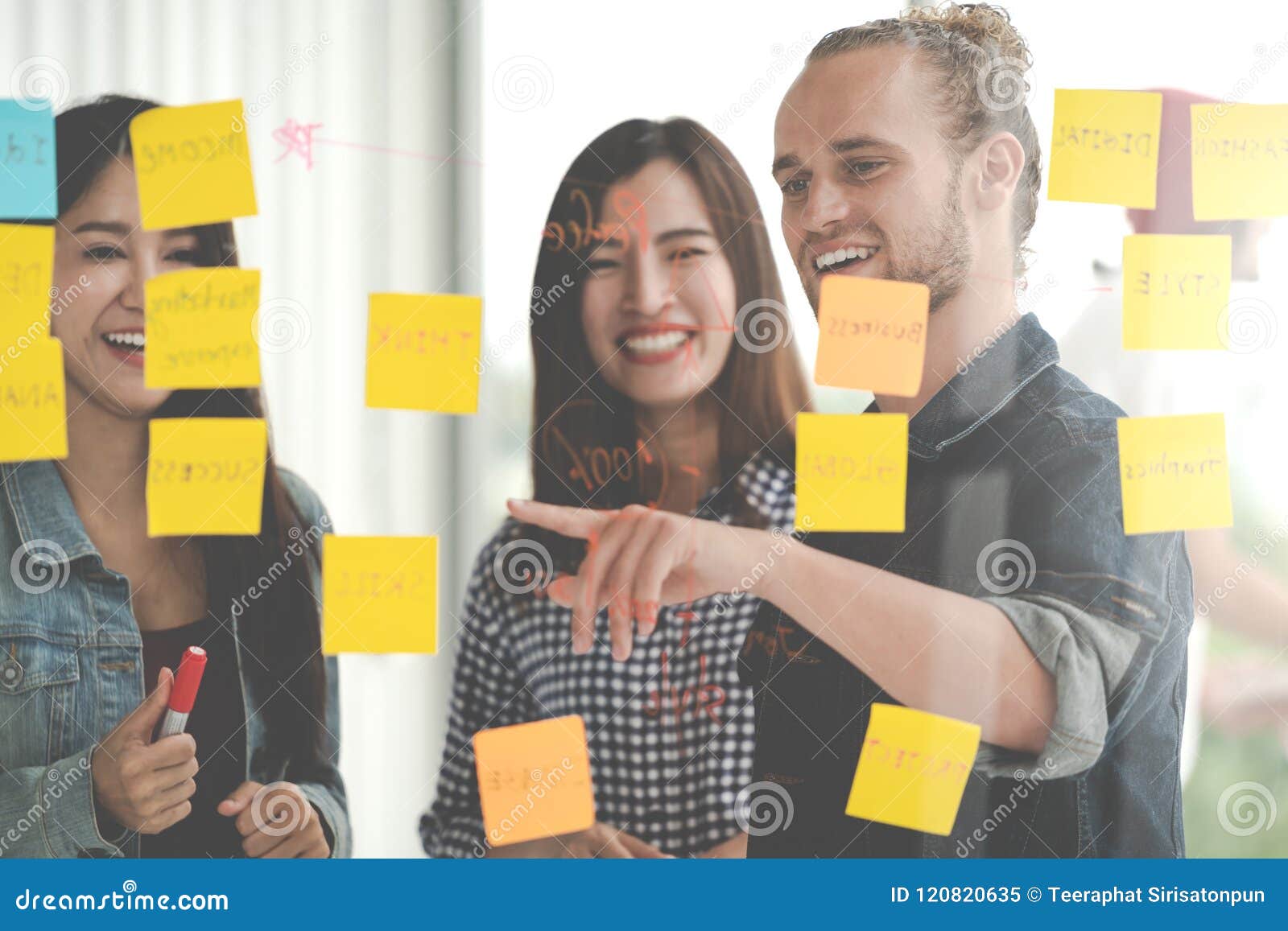 Group of Young Successful Creative Multiethnic Team Smile and Brainstorm on Project Together in ...