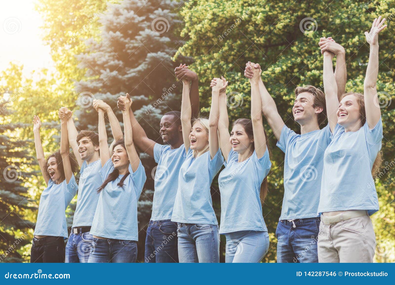 Group of Young Volunteers Join Hands in Park Stock Photo - Image of ...