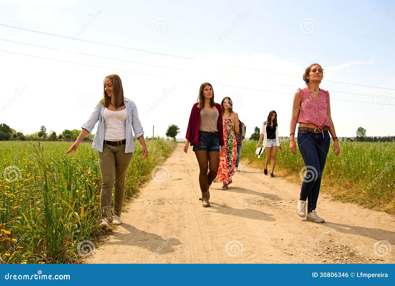 Group of Young Women Walking on a Field of Wildflowers Stock Photo ...
