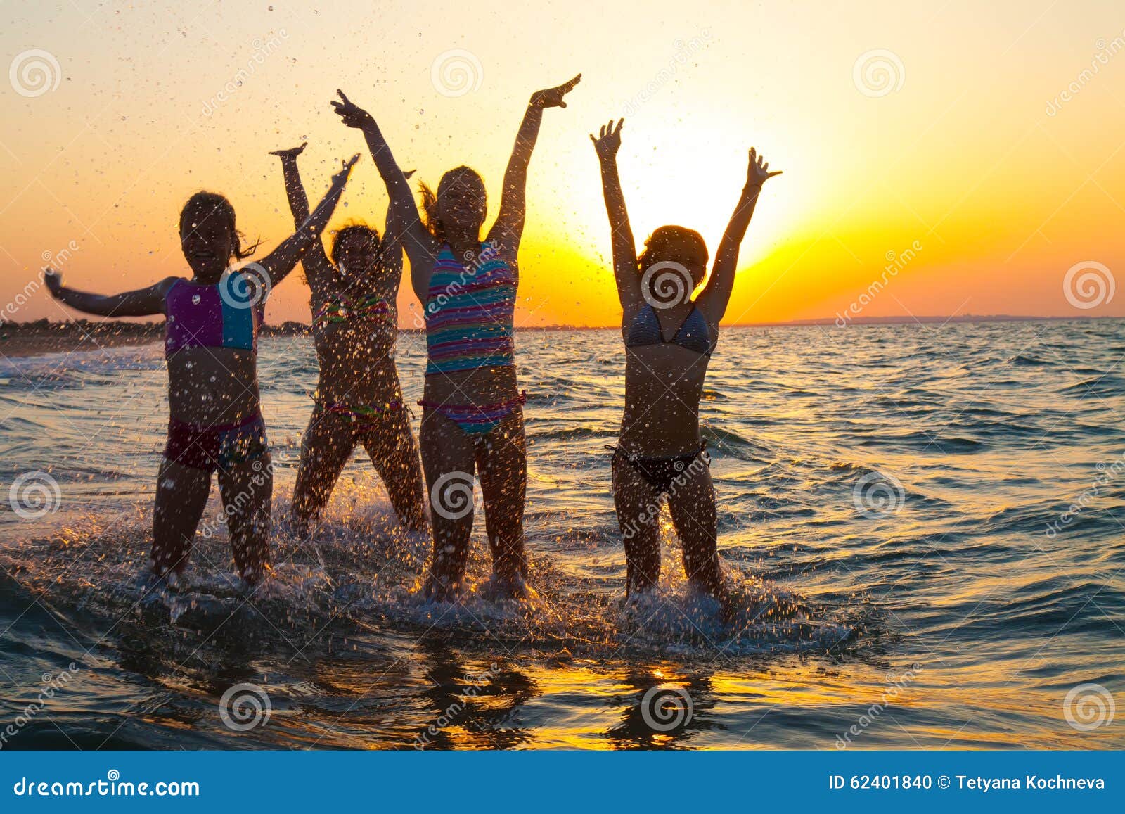 Groupe De Jeunes Filles Heureuses Sautant à La Plage Photo Stock