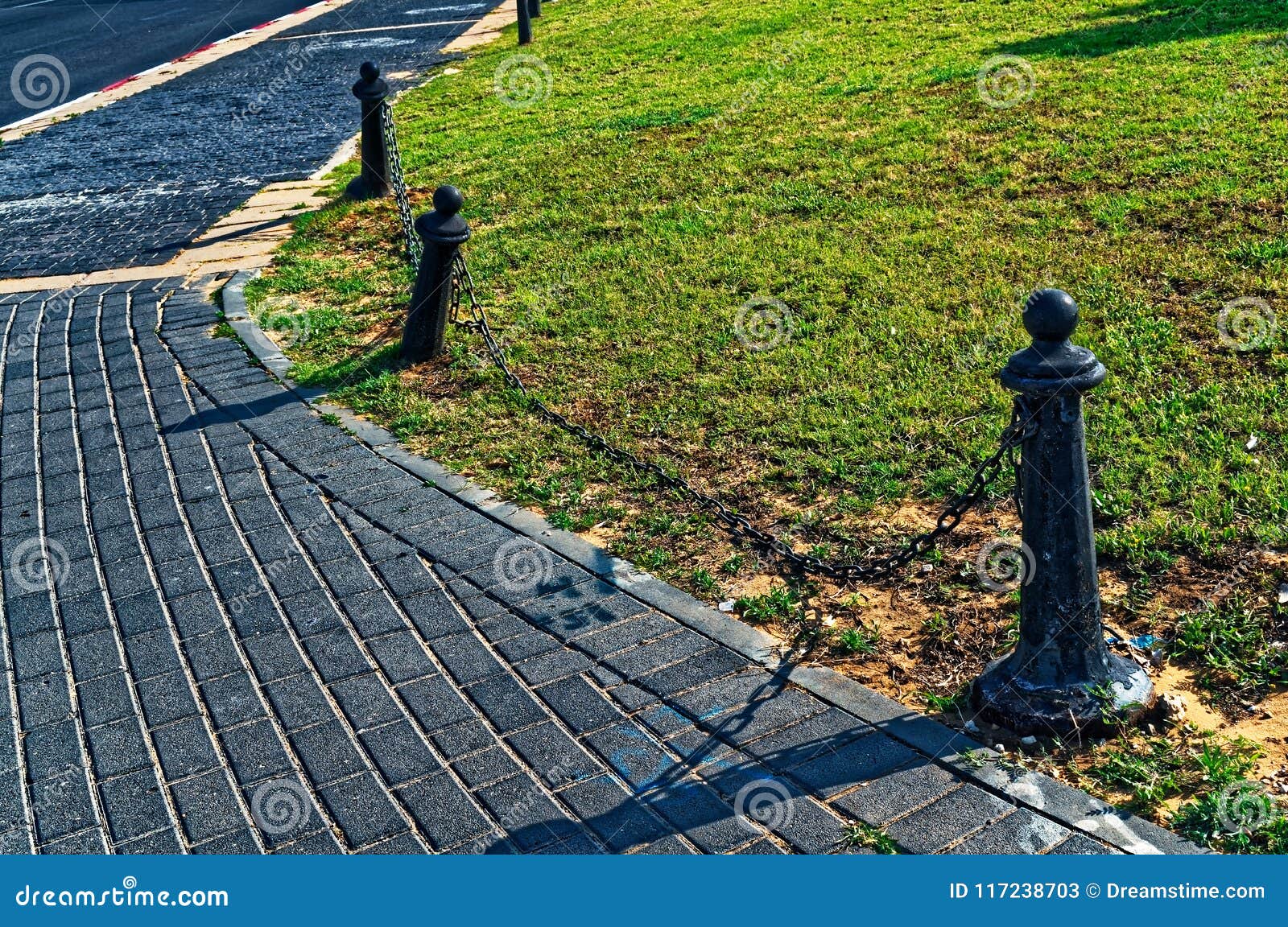 Guard Poles Connected with Chains between Grass and a Sidewalk Stock ...