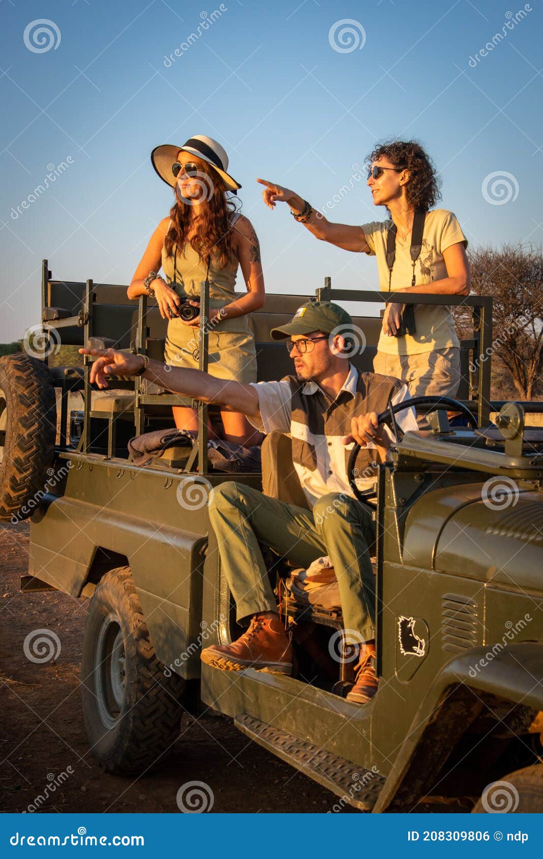 Guide and Guests Sit Pointing from Jeep Stock Photo - Image of grass ...