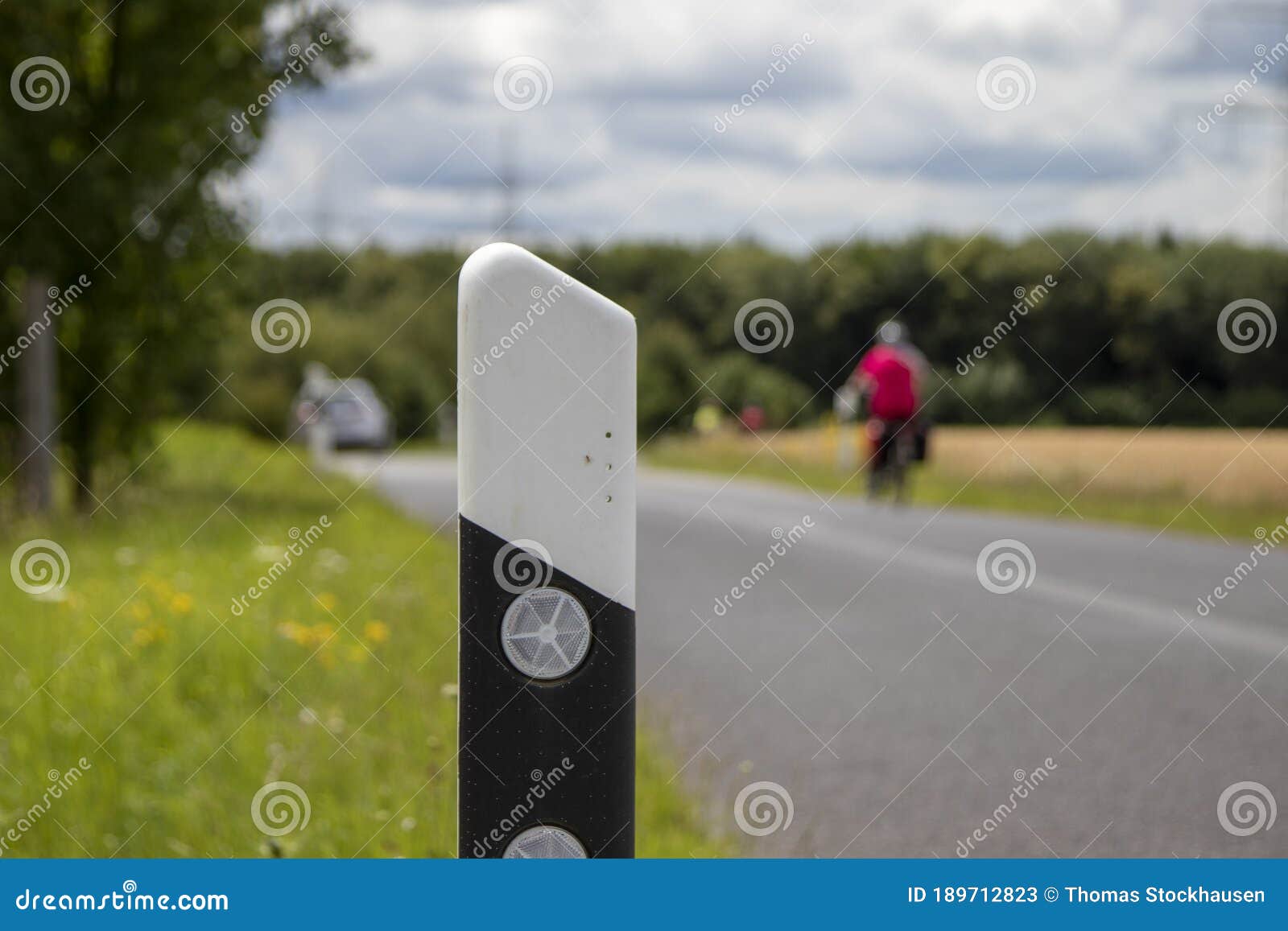 Guide Post with Reflector on a Country Road with a Cyclist in the ...