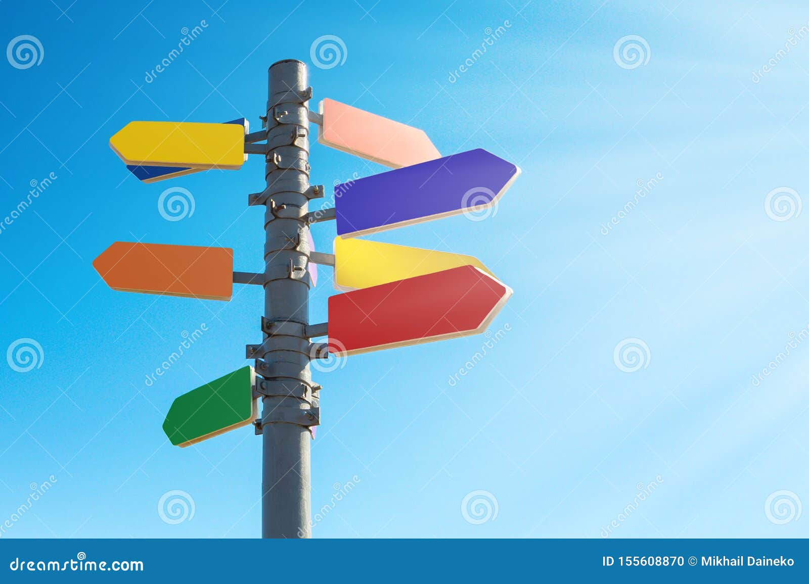 Guidepost with Arrows in the Sunlight Against Blue Sky Stock Photo ...