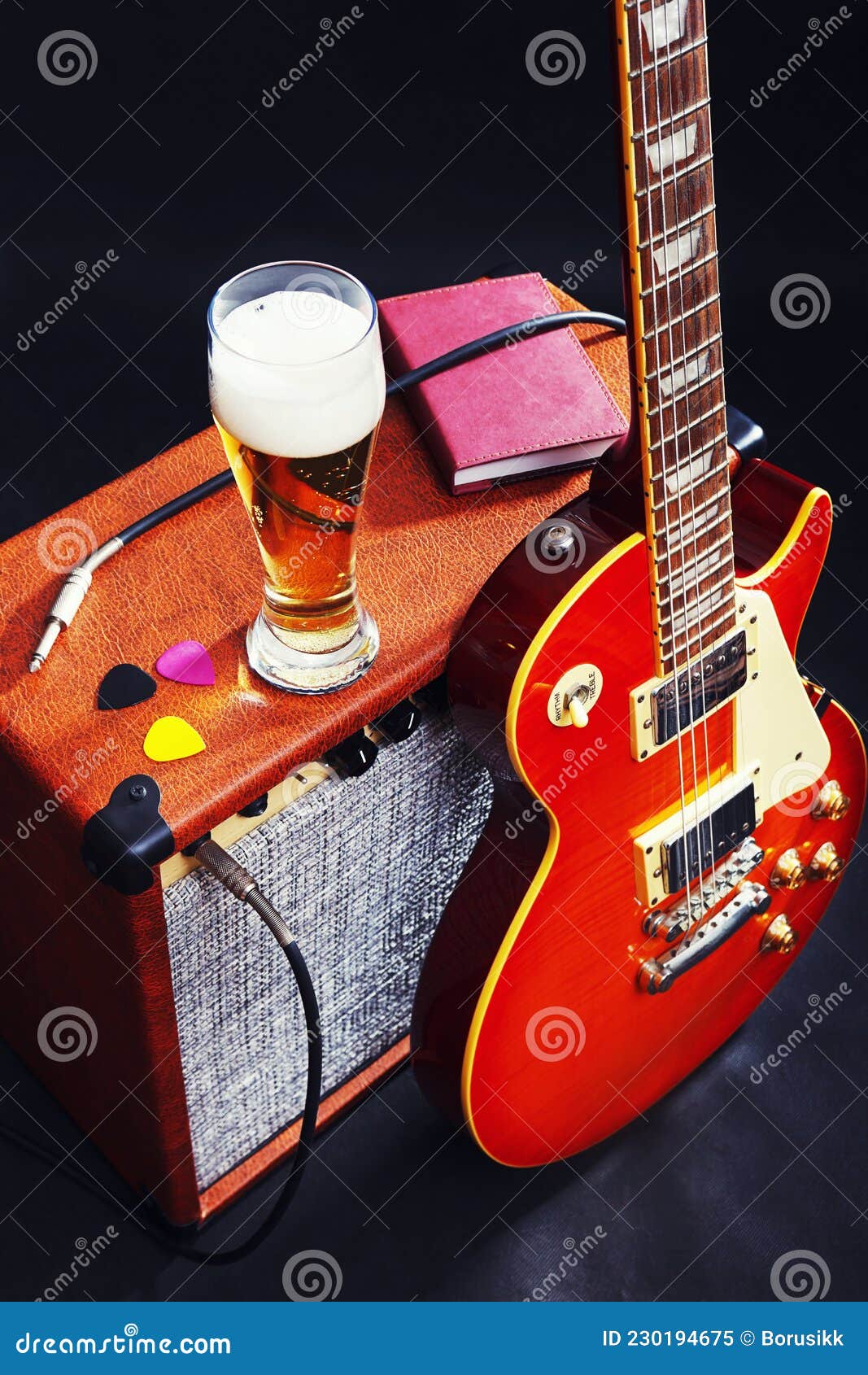 Guitar Amplifier with Guitar, Glass of Beer and Notepad on Black ...