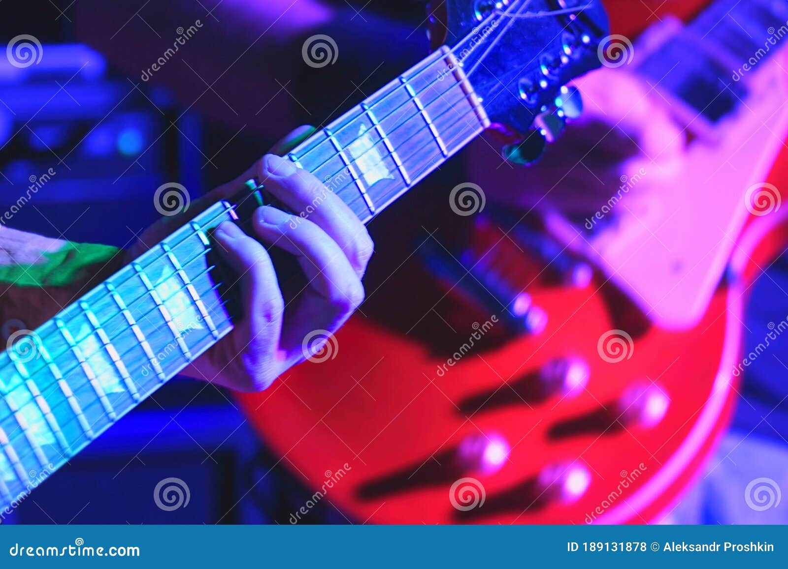 Guitar in the Hands of a Guitarist Standing on Stage in Spotlight Stock ...