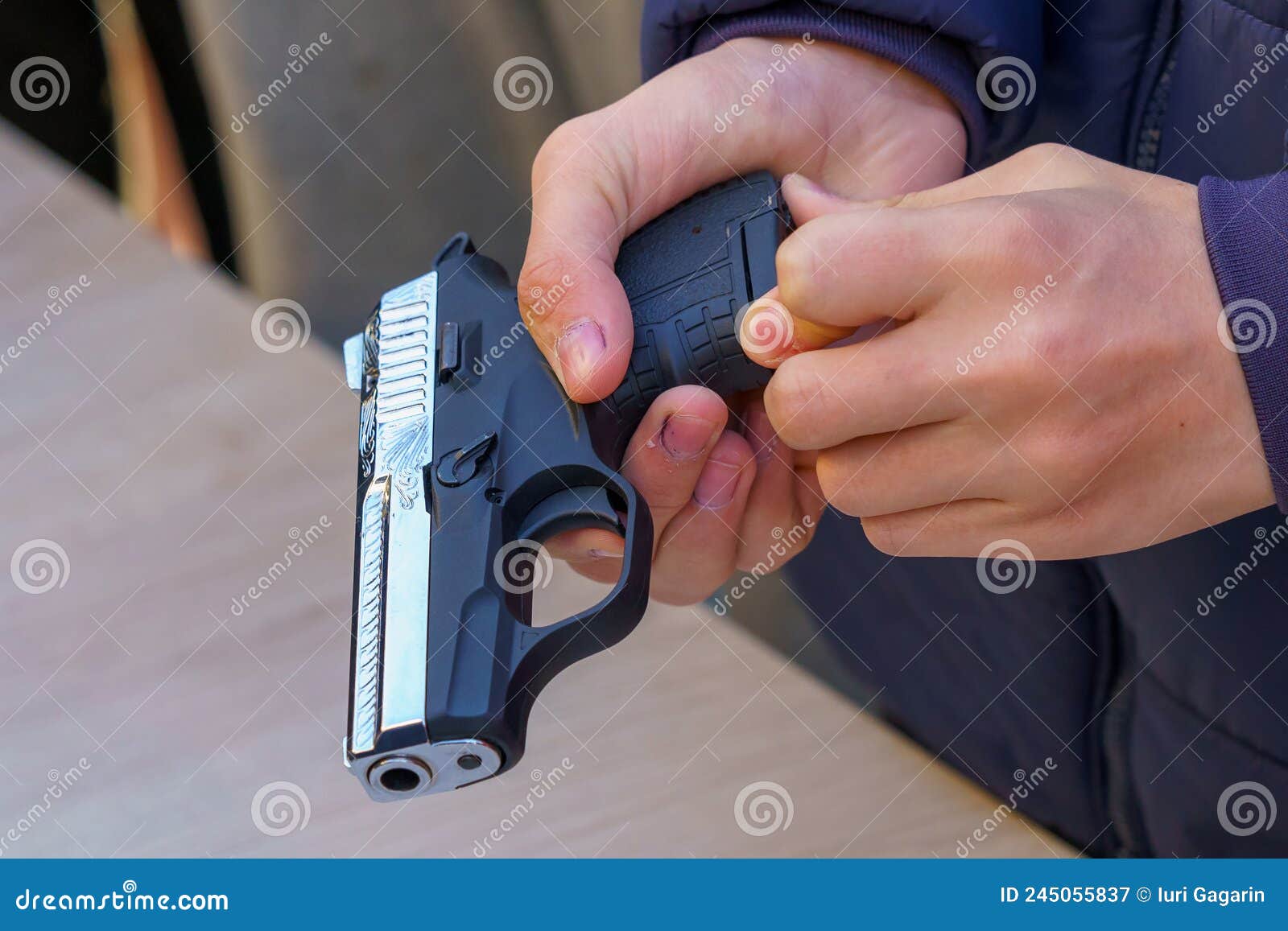 A Gun in the Hands of a Young Man, Selective Focus. Reloading Weapons ...