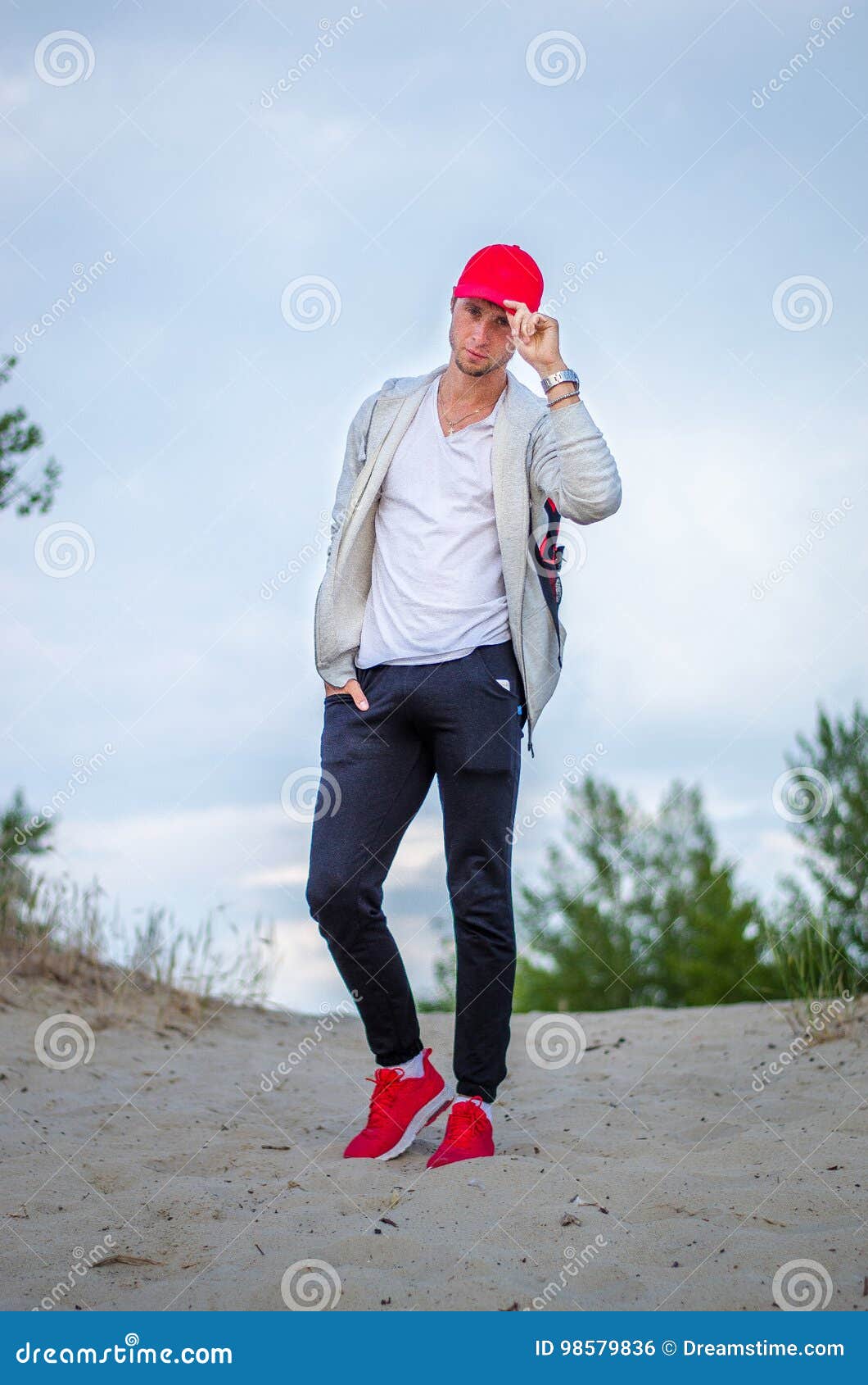 The guy adjusts the cap stock photo. Image of blue, park - 98579836