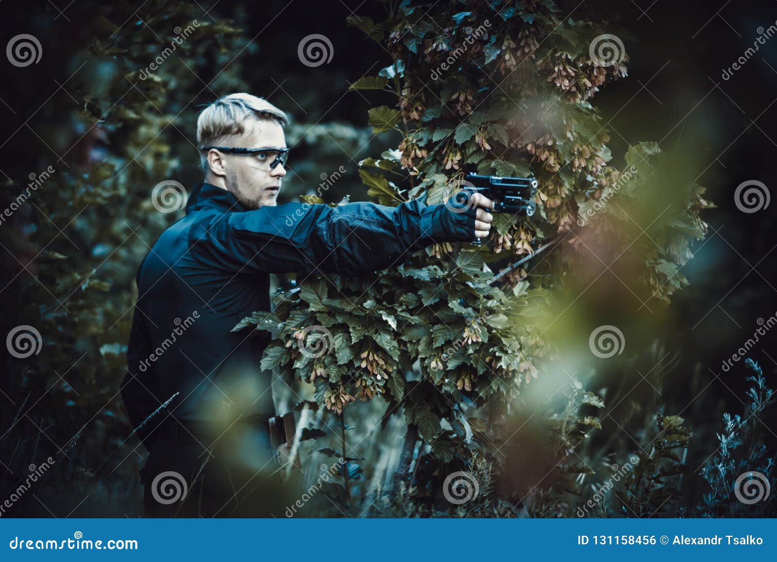 Instructor with Gun in Forest Leads Aiming and Posing on Camera Stock ...