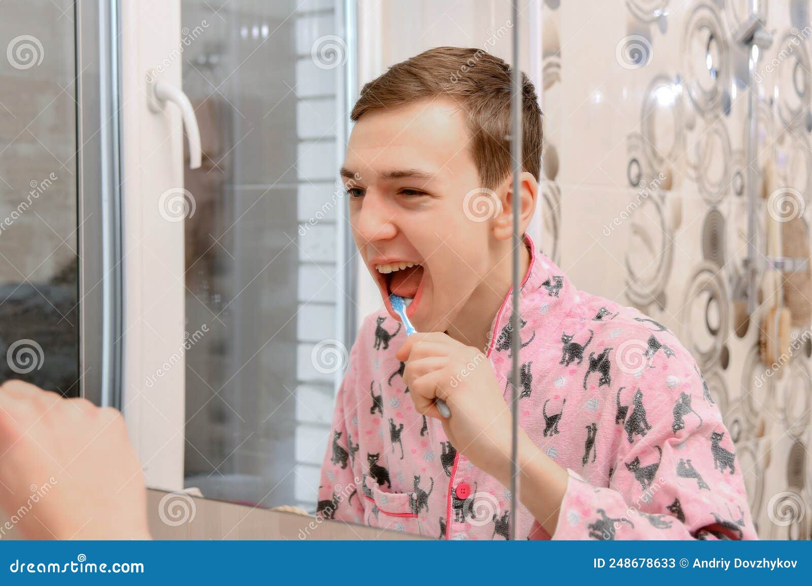 The Guy in the Bathroom Brushes His Teeth with a Toothbrush in Front of ...