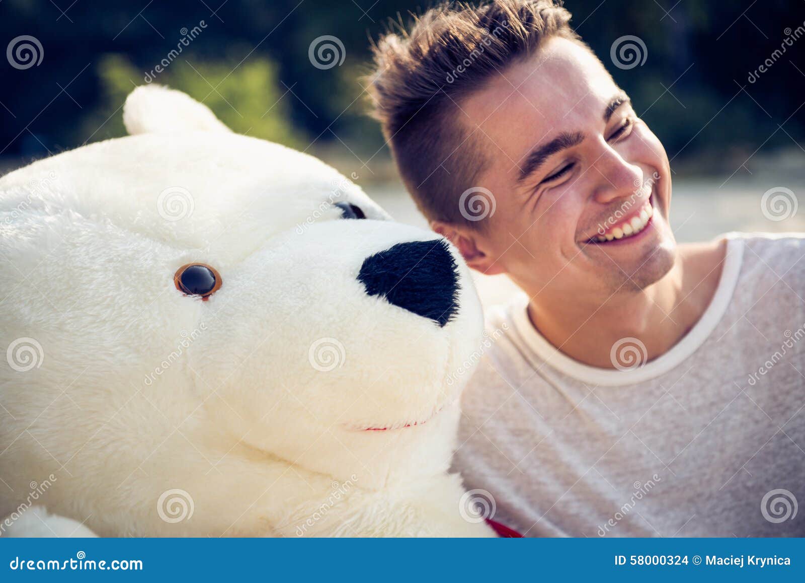 Guy with a big teddy bear stock photo. Image of friends - 58000324