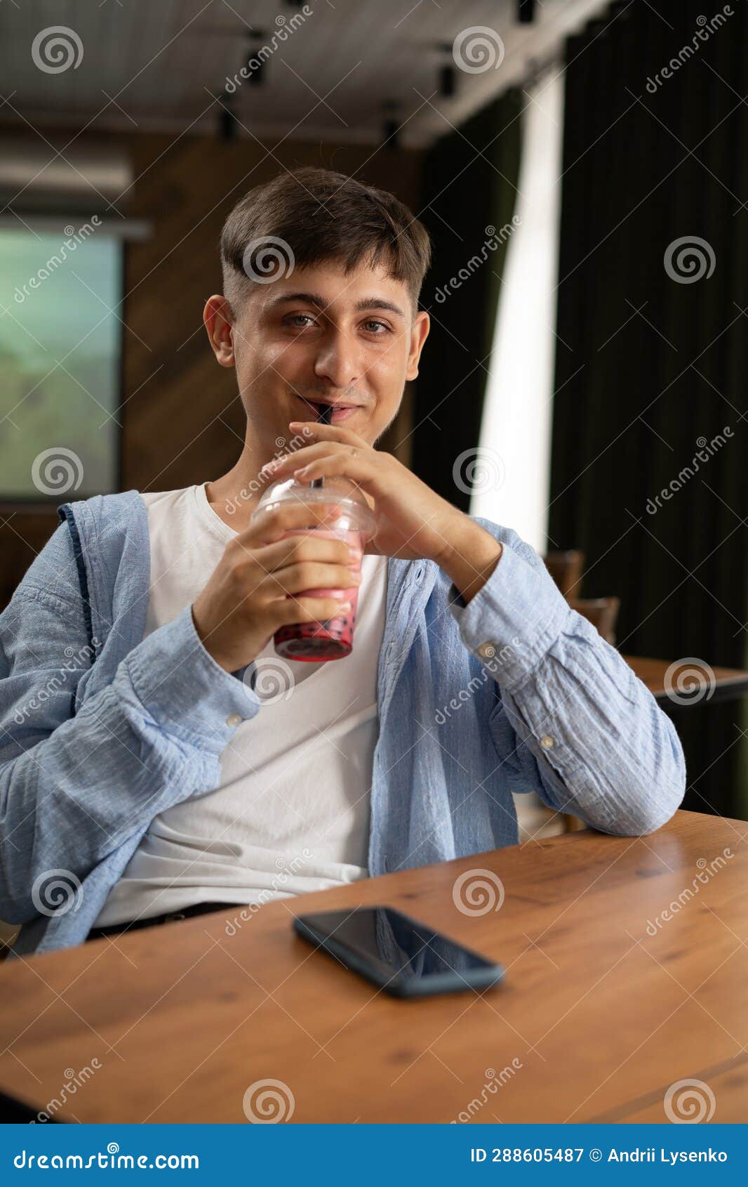 The Guy Drinks Delicious Bubble Tea while Sitting at a Table in a Cafe ...