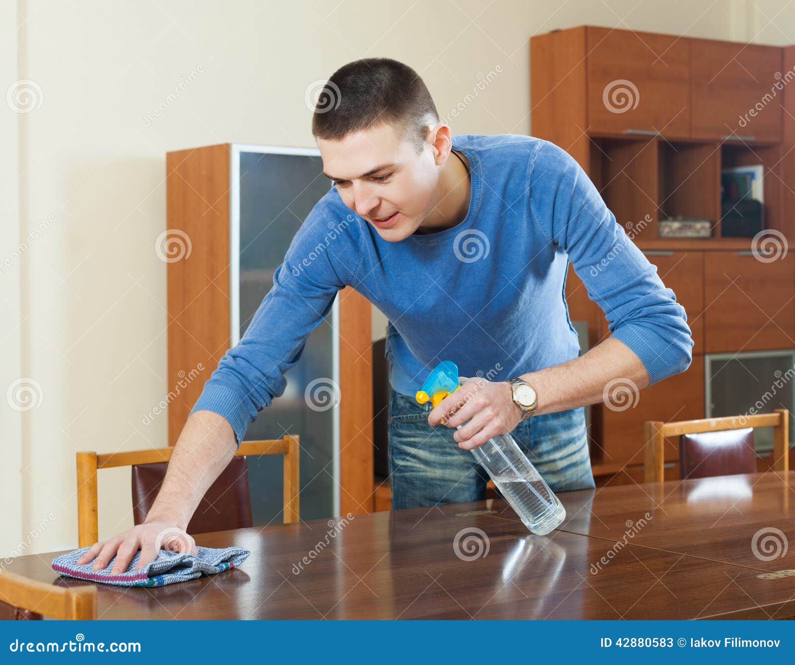 Guy Dusting Wooden Table with Rag and Cleanser at Home Stock Image ...