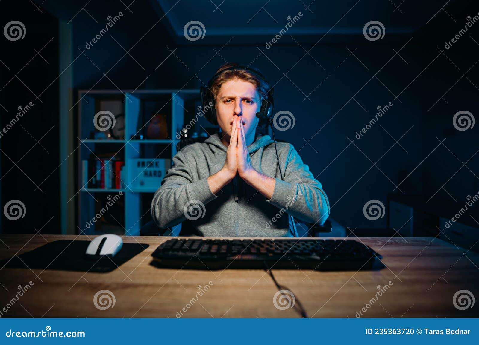 Guy Gamer Sits in a Headset at Home at Night at the Computer and Prays ...
