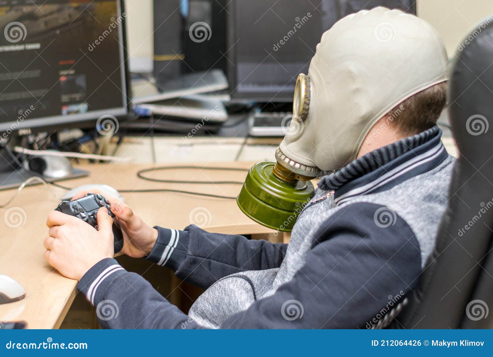 A Guy in a Gas Mask with a Game Console in His Hands is Playing a ...