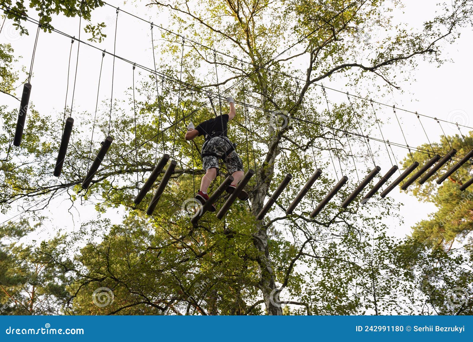 The Guy Goes through the Obstacle Course on the Rope Park Stock Photo ...