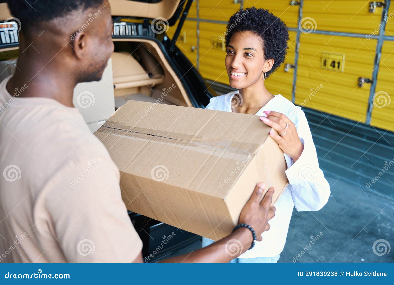 Guy and His Girlfriend are Unloading Boxes of Things from a Car Stock ...
