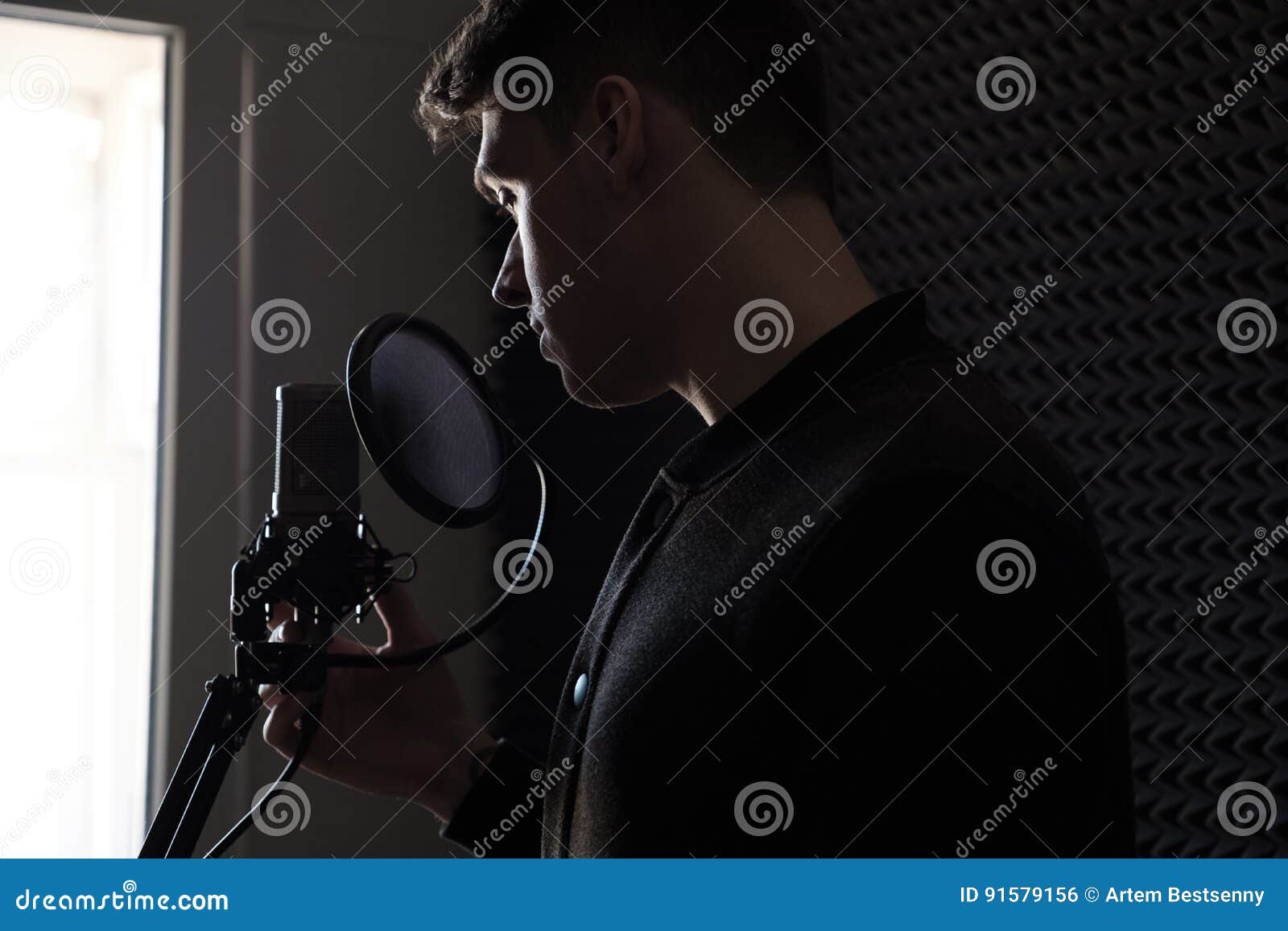 The Guy is Holding a Microphone Standing on the Counter in Front of Him ...