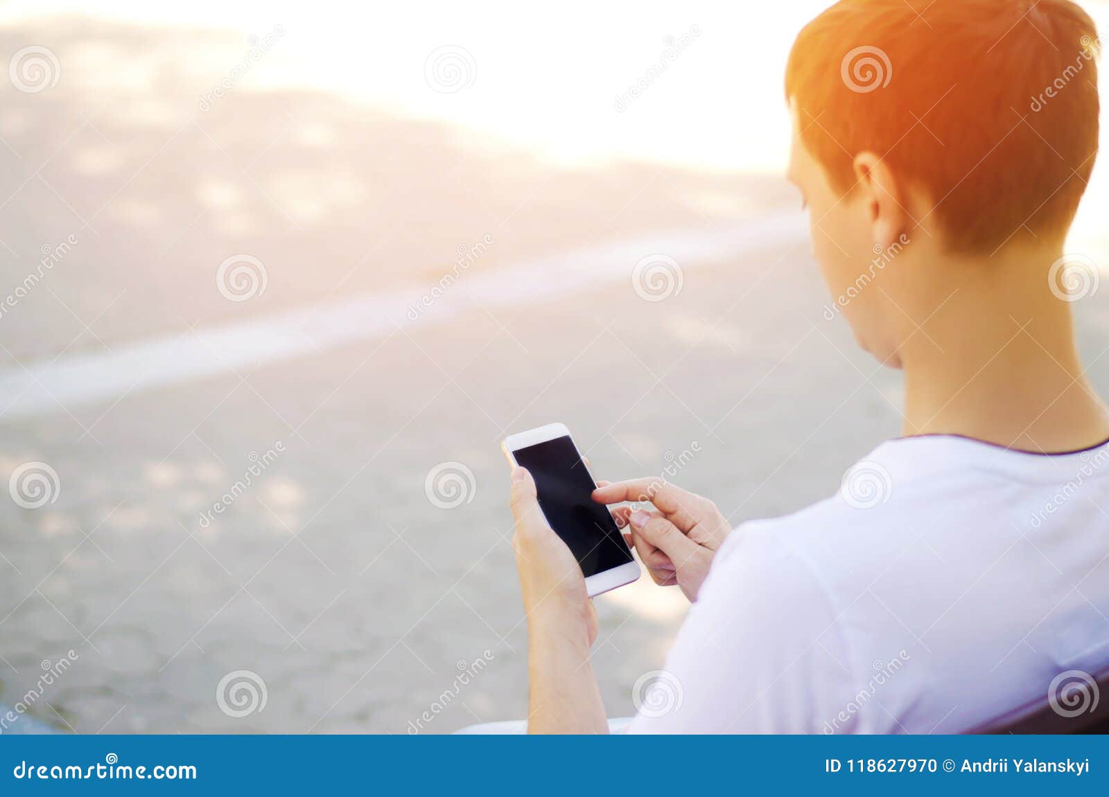 The Guy is Holding a Mobile Smartphone and Looking at the Screen ...