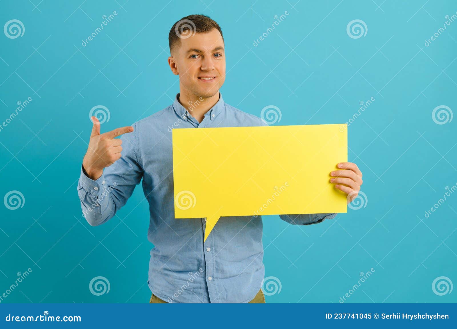 Guy Holding Speech Bubble on Blue Studio Background, Mockup for Design ...