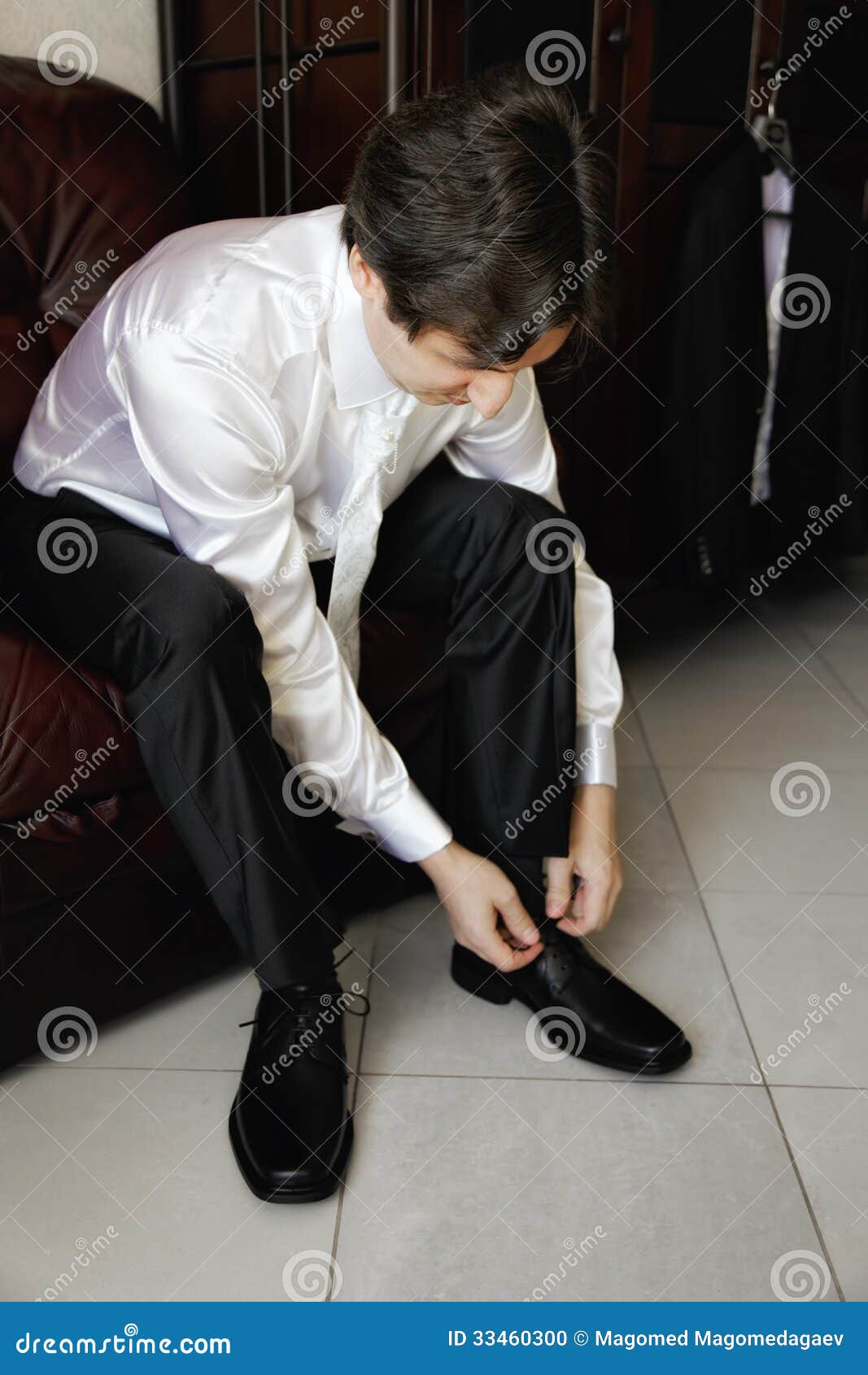 Guy lacing up shoes stock photo. Image of shirt, leather - 33460300