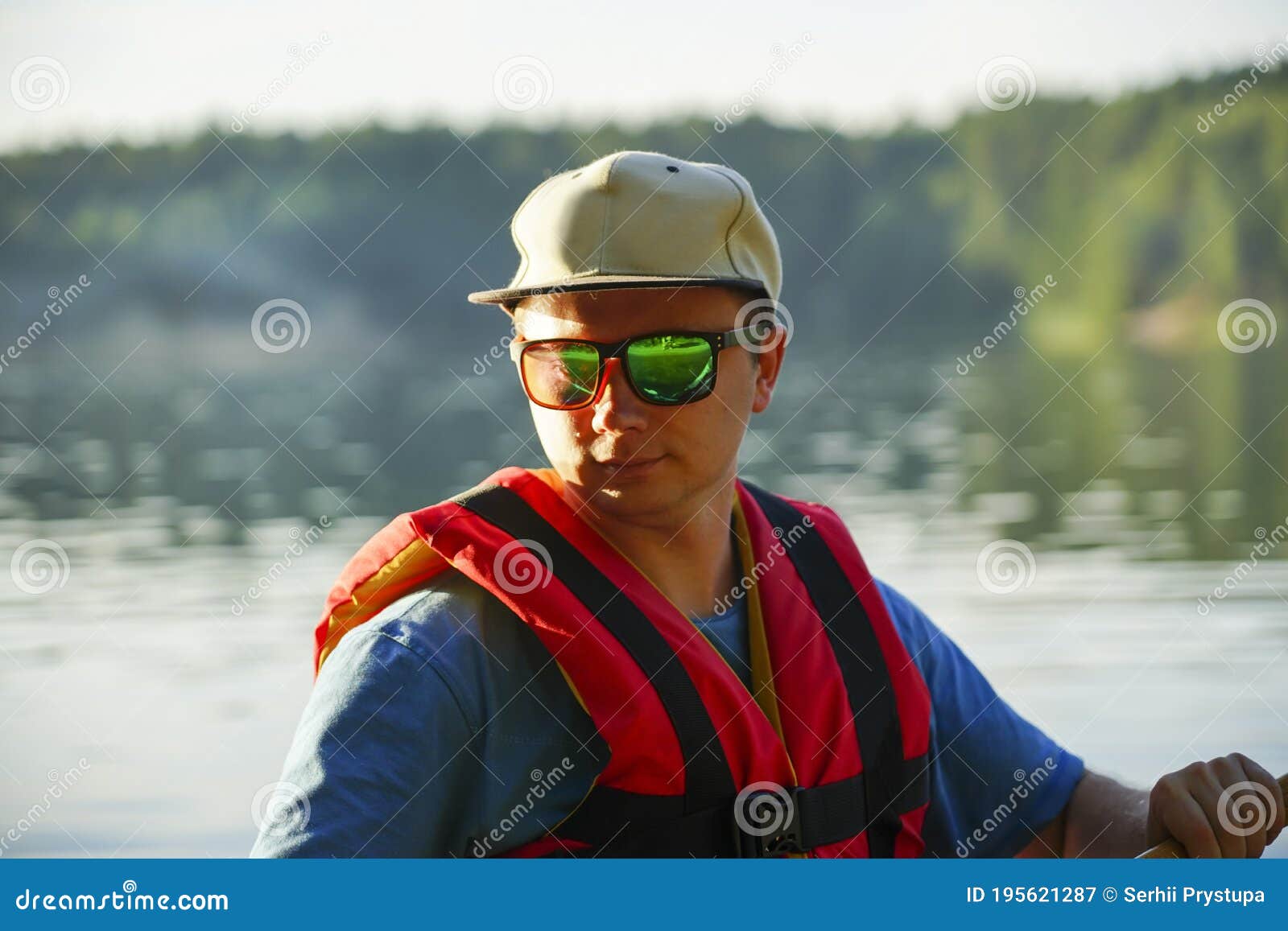 A Guy in a Life Jacket Holds a Paddle in His Hands while Sleeping on a ...