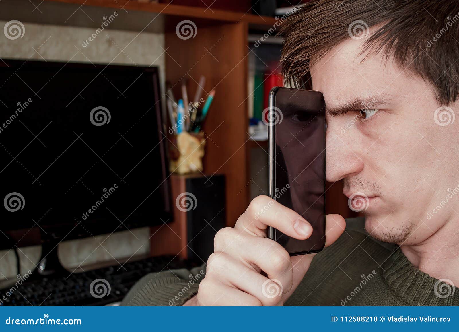 Guy Looks at the Screen of a Black Smartphone, through the Reflection ...