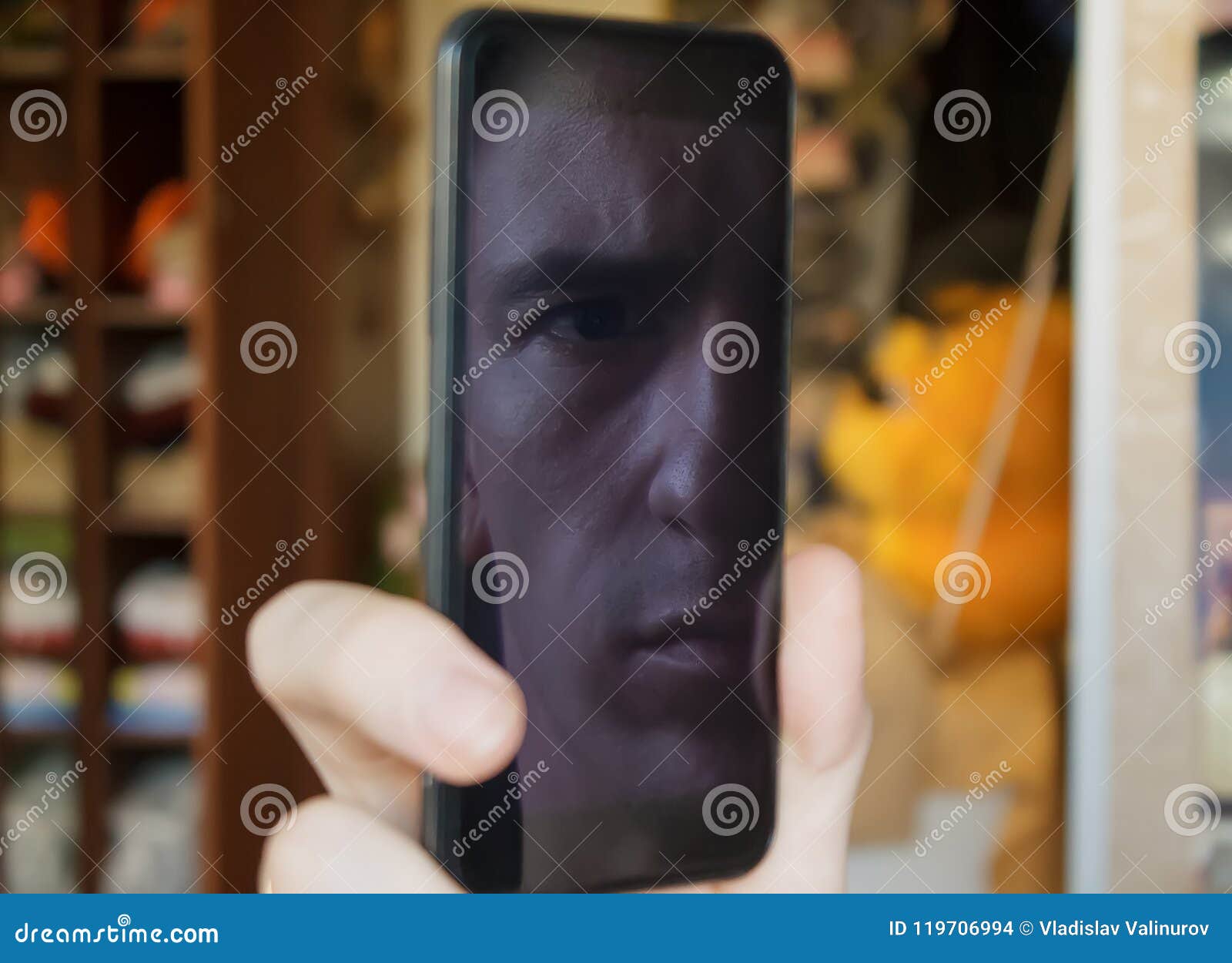Guy Looks at the Screen of a Black Smartphone, through the Reflection ...