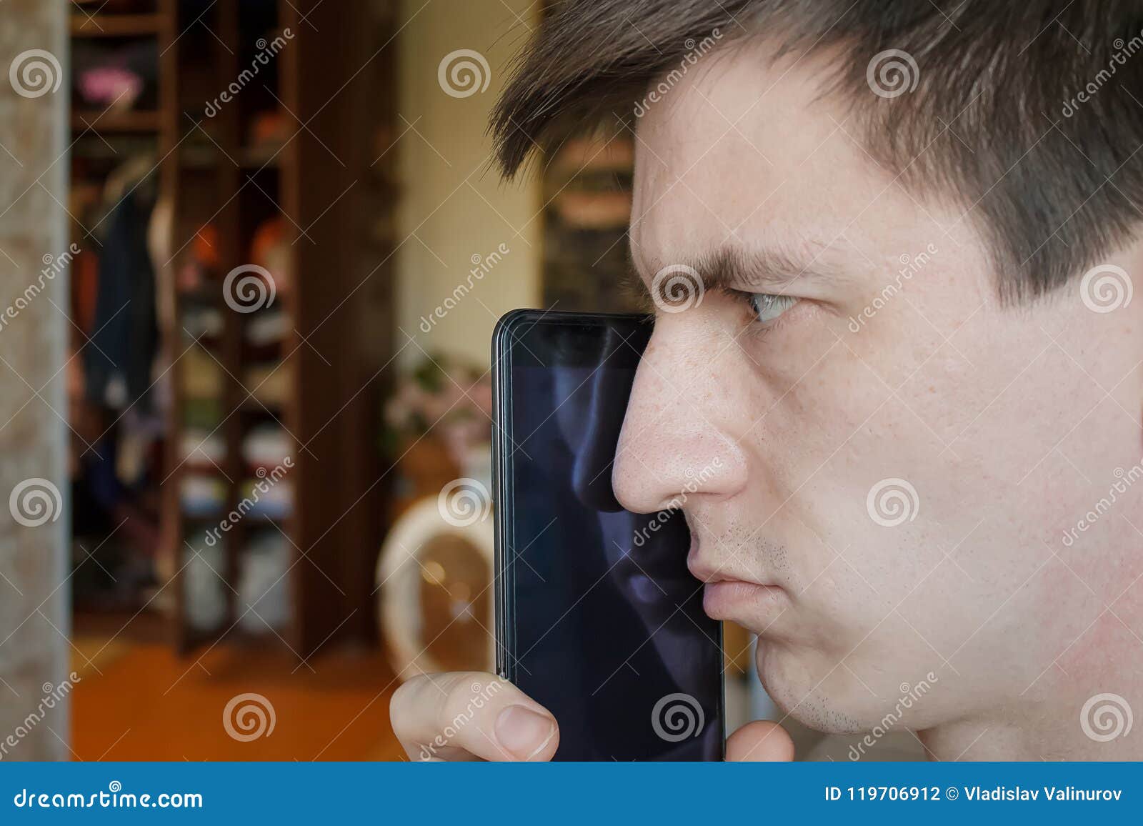 Guy Looks at the Screen of a Black Smartphone, through the Reflection ...