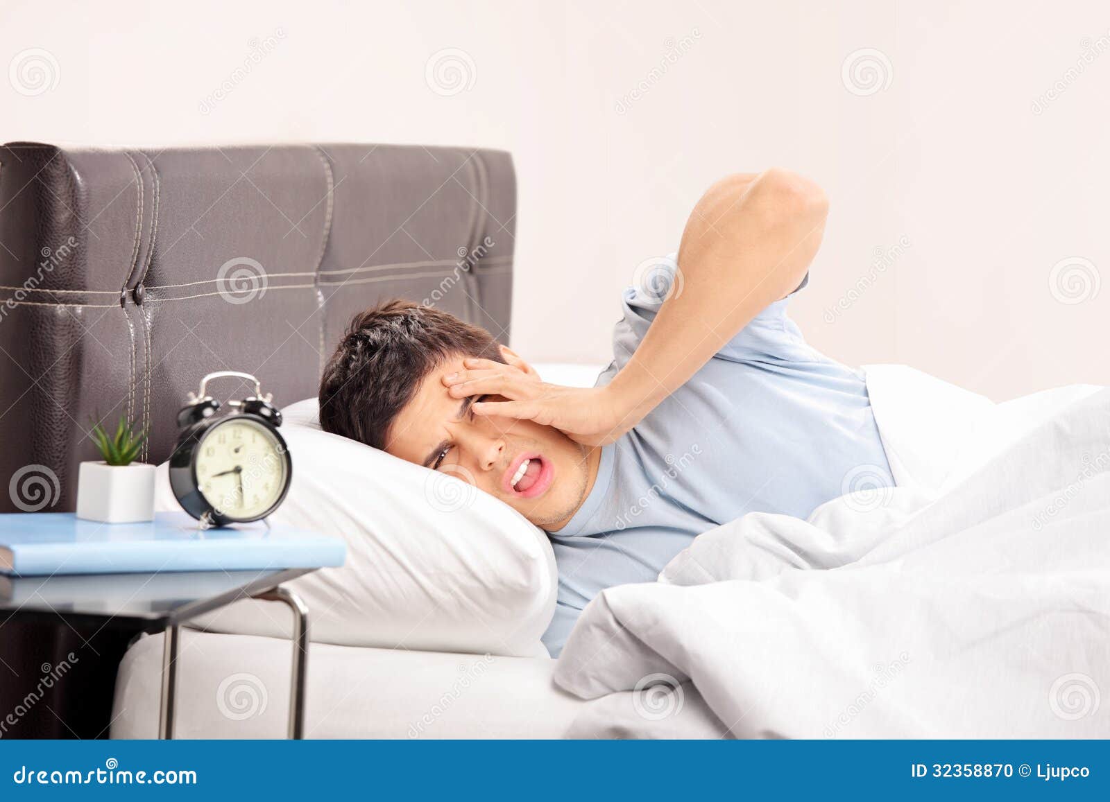 Guy Lying on a Bed and Gesturing Late Stock Photo - Image of panic ...