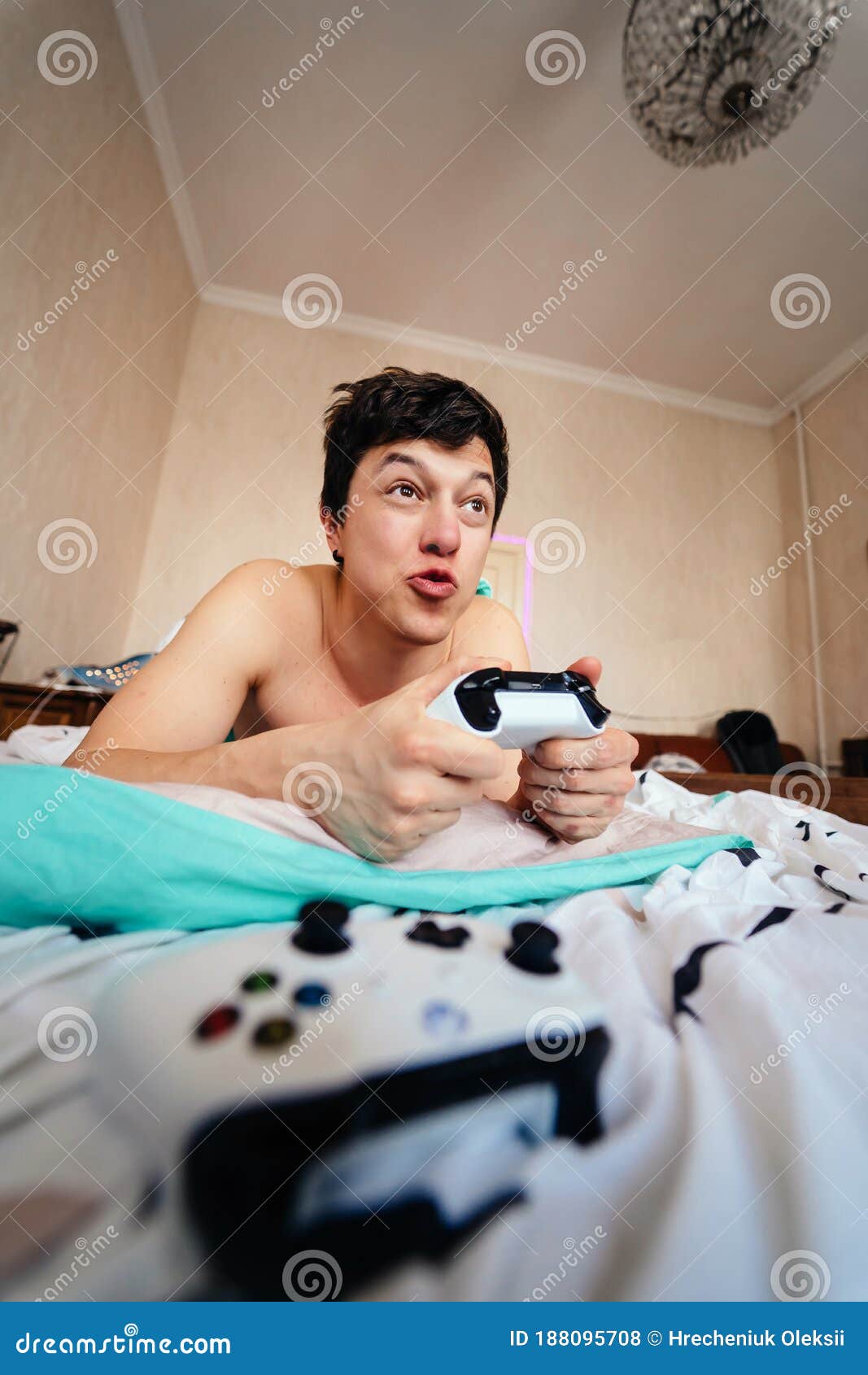Guy Lying in Bed and Playing Video Game, Holding Controller Stock Photo ...